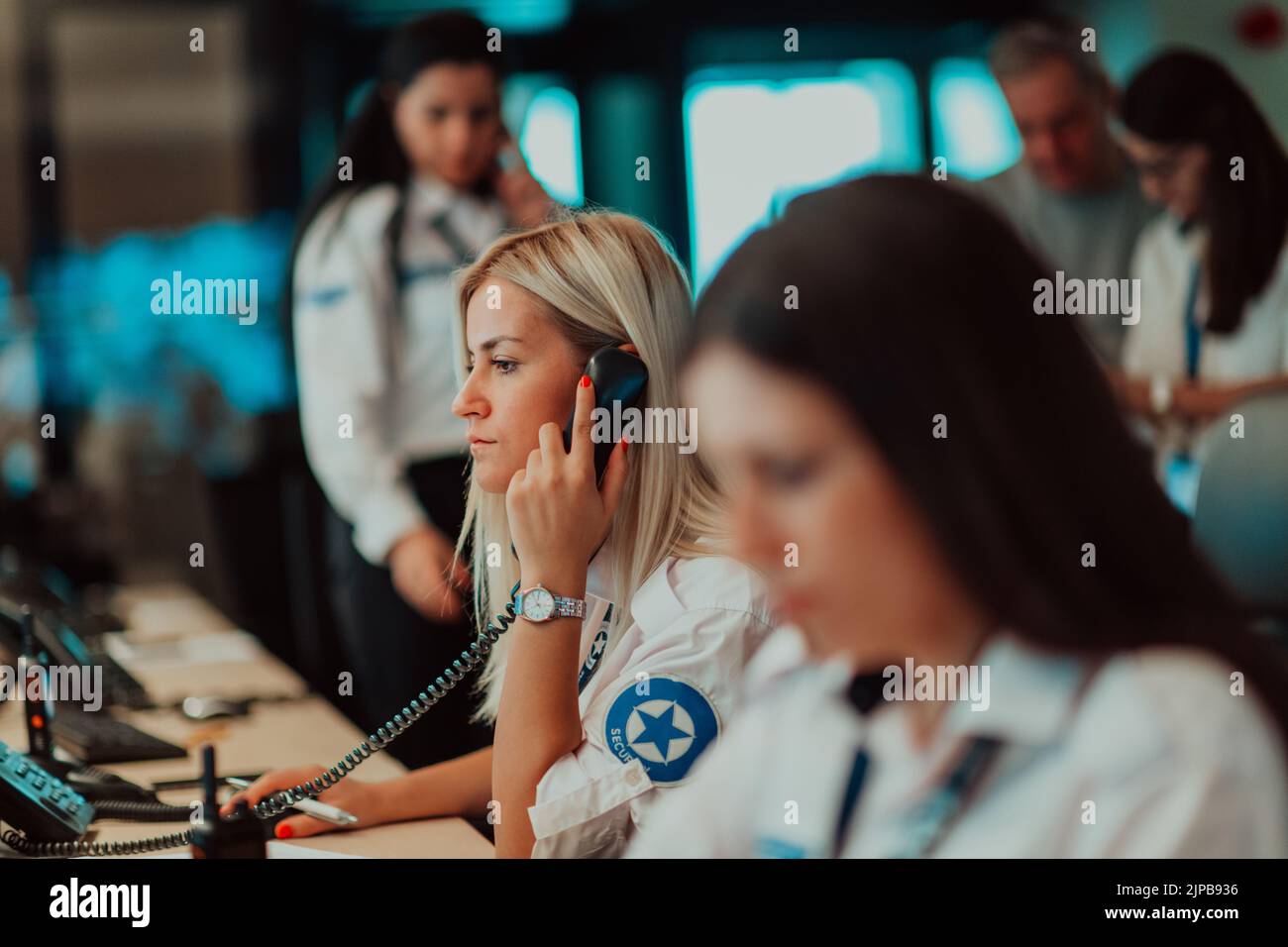 Female security guard operator talking on the phone while working at ...