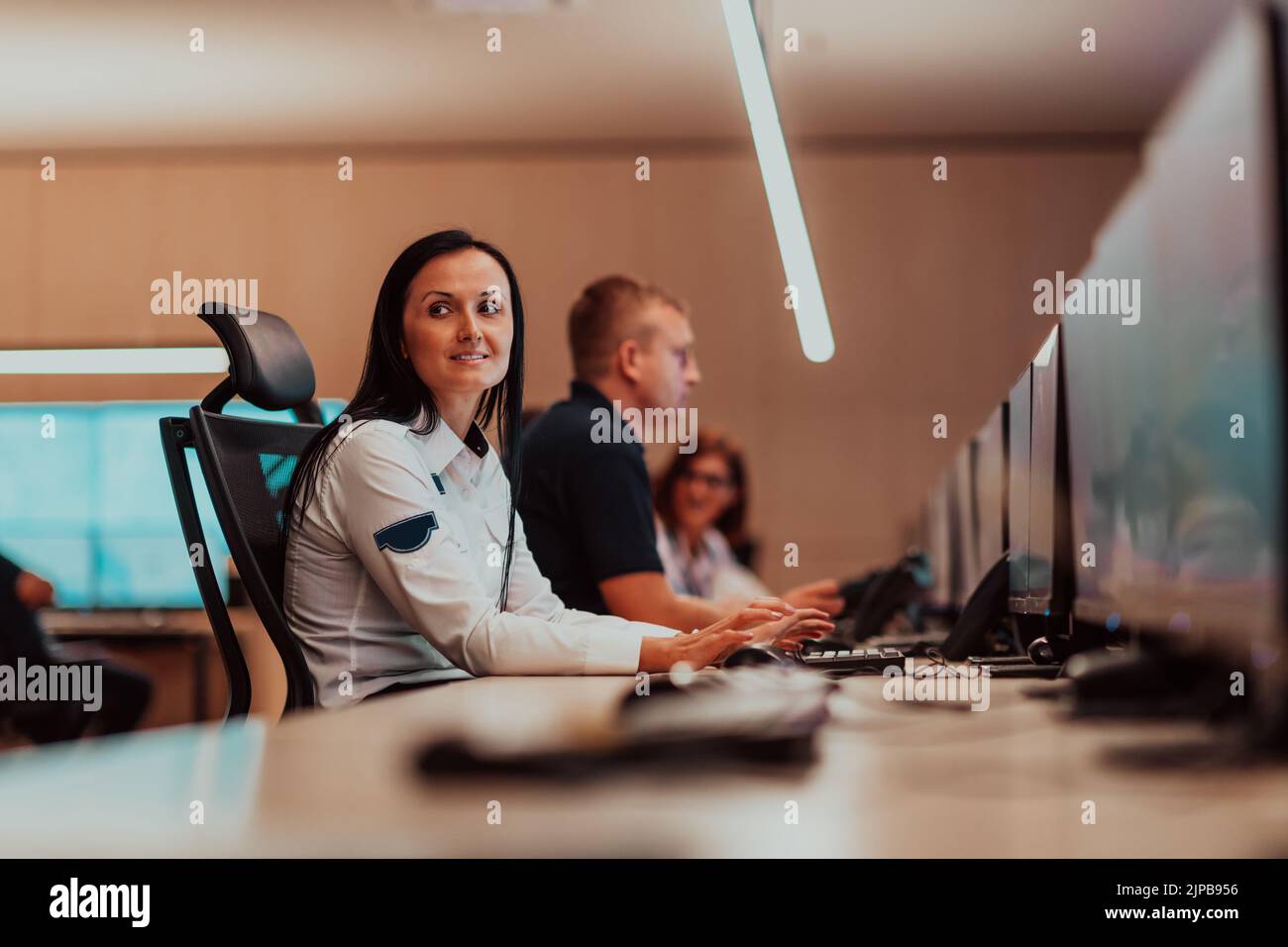 Female security operator working in a data system control room offices ...