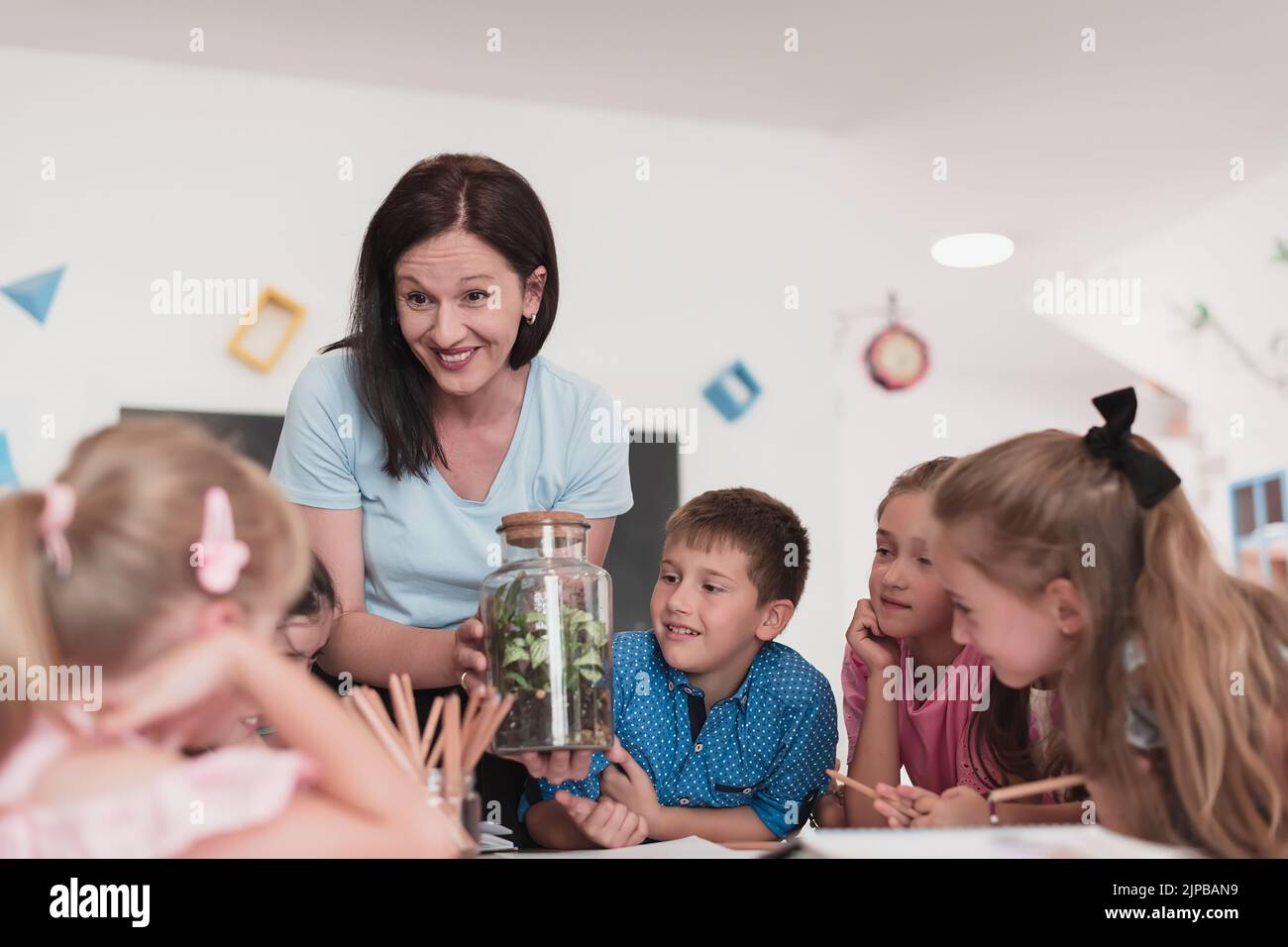 Female Teacher with kids in biology class at elementary school ...