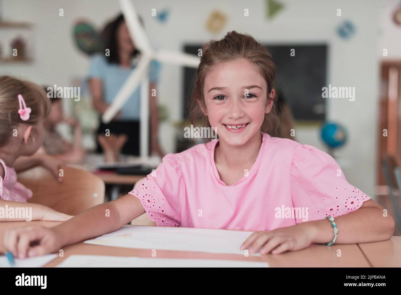 Little girls sitting in elementary school drawing on paper with their ...