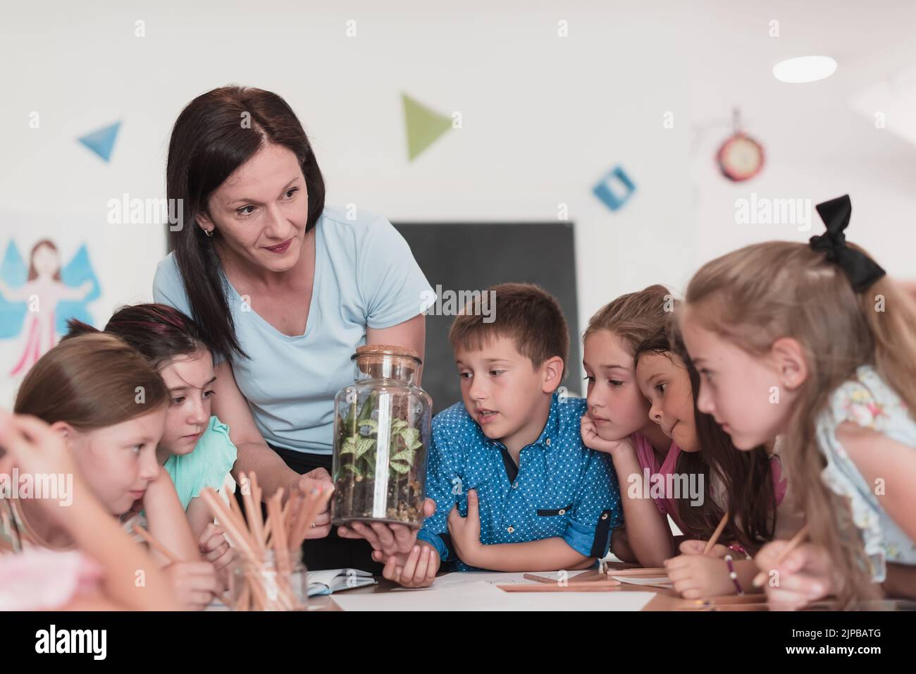 Female Teacher with kids in biology class at elementary school ...