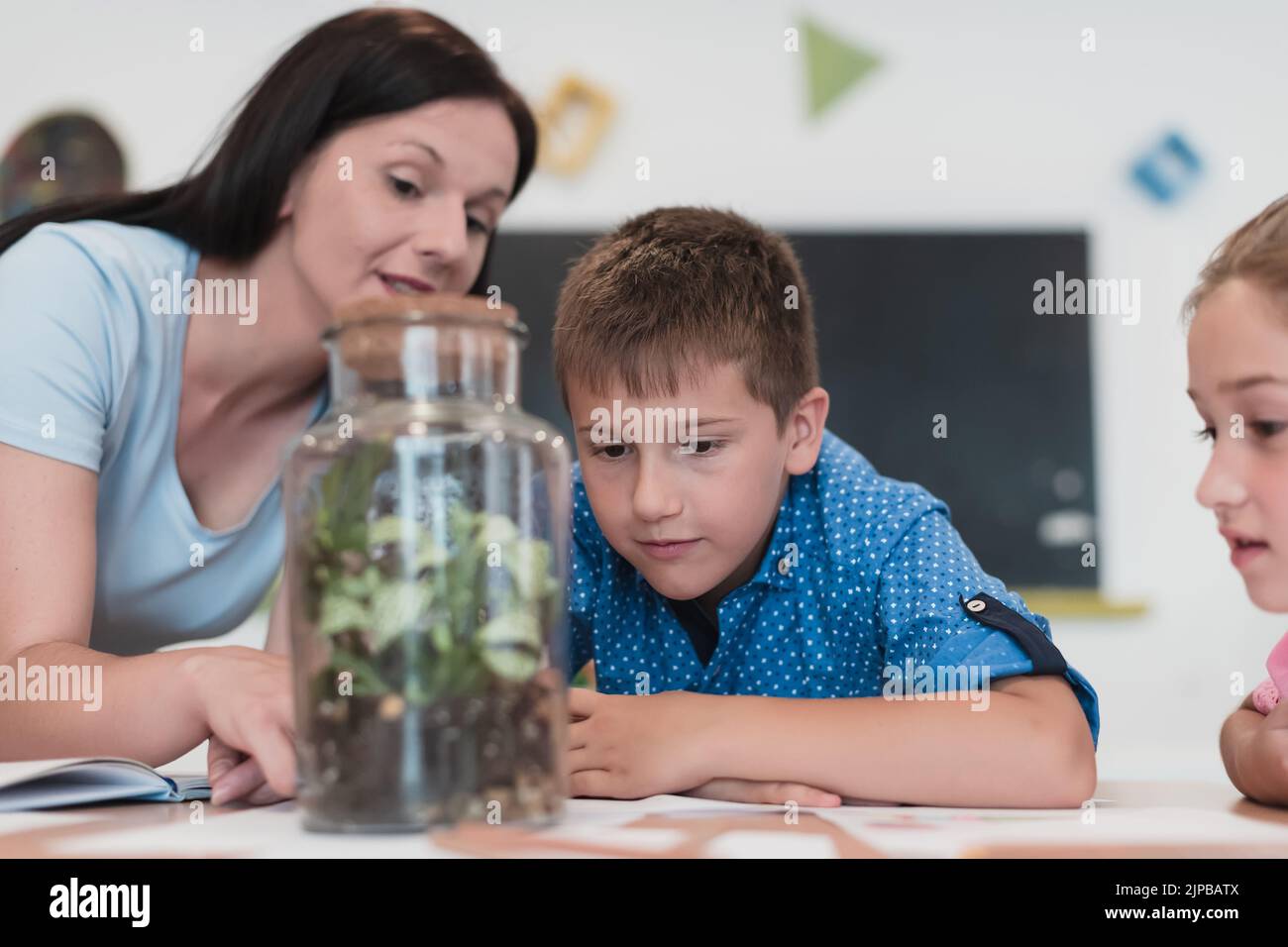 Female Teacher with kids in biology class at elementary school ...