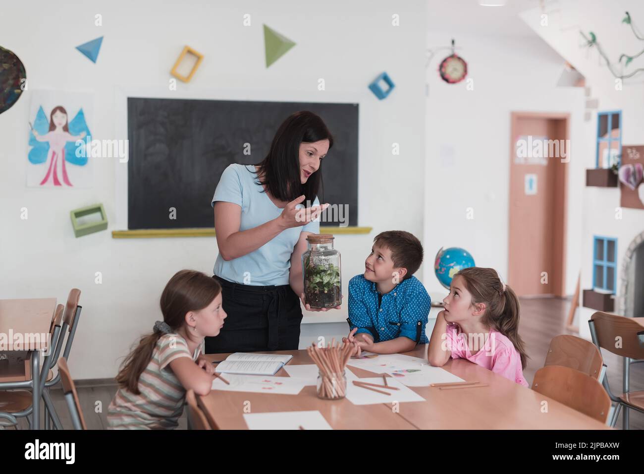 Female Teacher with kids in biology class at elementary school ...