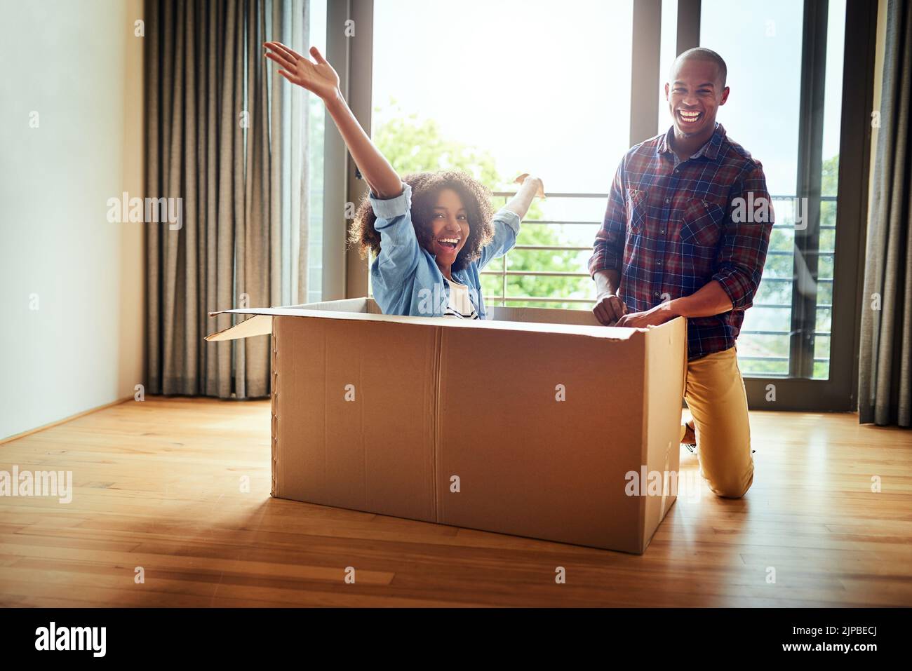 Surprise everyone. a cheerful woman inside of a cardboard box with her ...