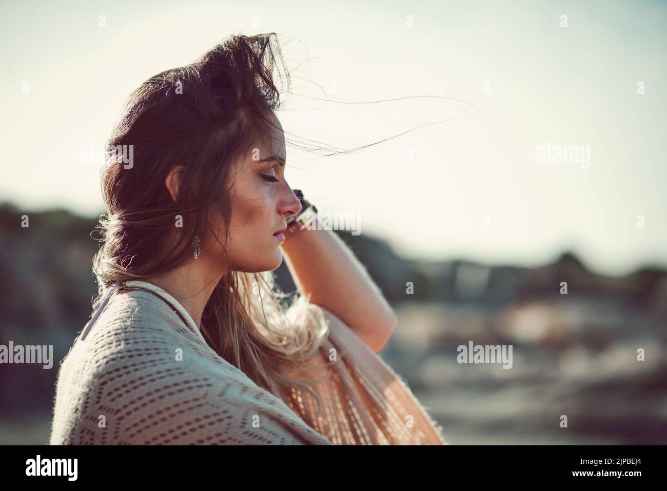 Taking in the smell of the ocean. an attractive young woman spending a ...