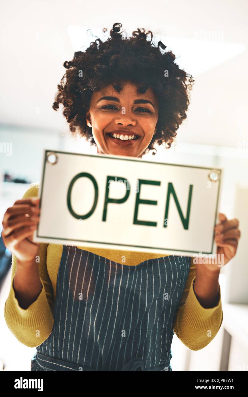 Happy to see my favourite customer. a young woman holding up an open ...