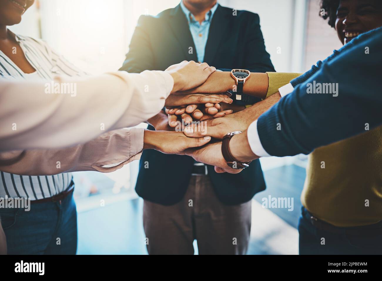 Its a matter of teamwork. Closeup shot of an unrecognizable group of businesspeople joining ...