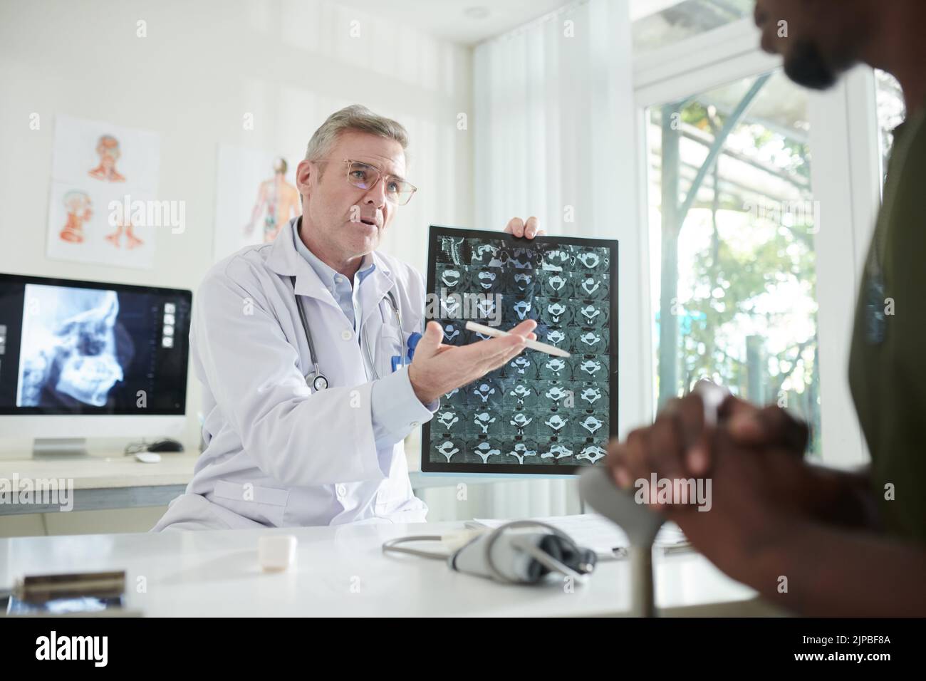 Serious general practitioner talking to military man about back pain ...