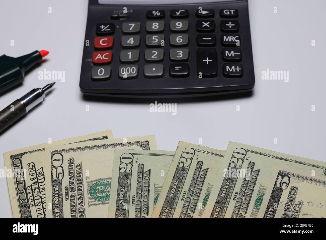 Calculator and dollars isolated on white background Stock Photo - Alamy