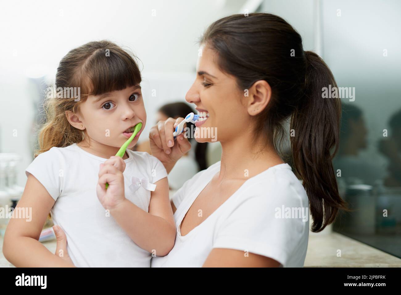 This is the way we brush our teeth. Portrait of a mother and daughter ...