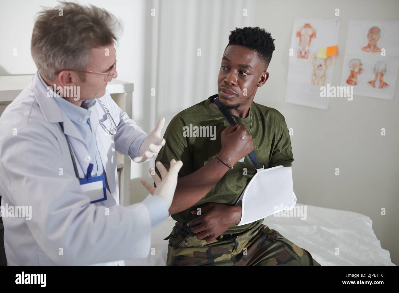 Doctor explaining military man with broken arm how to adapt to live ...