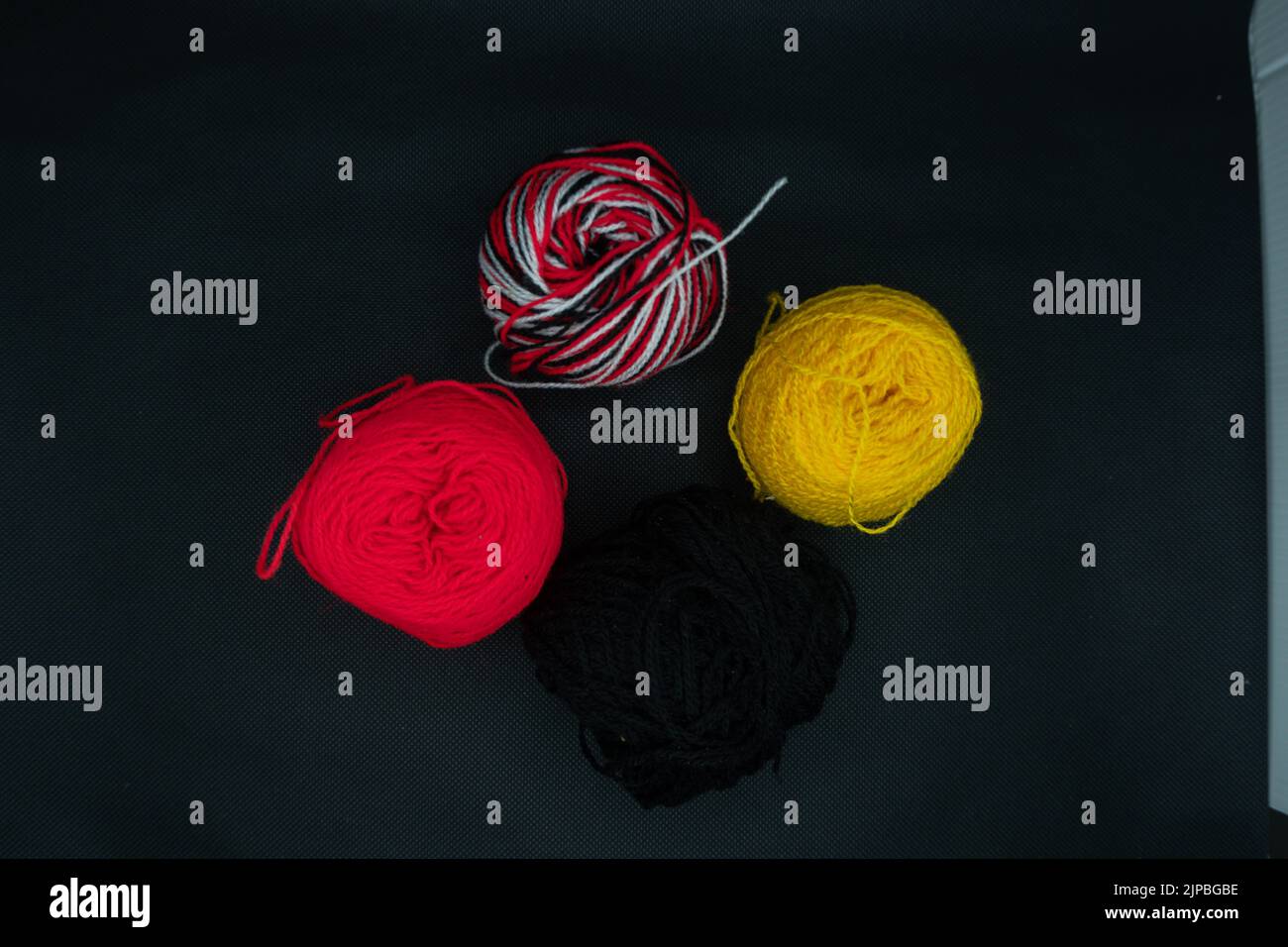 Red, Yellow, Black and multi collor woolen balls over black background ...