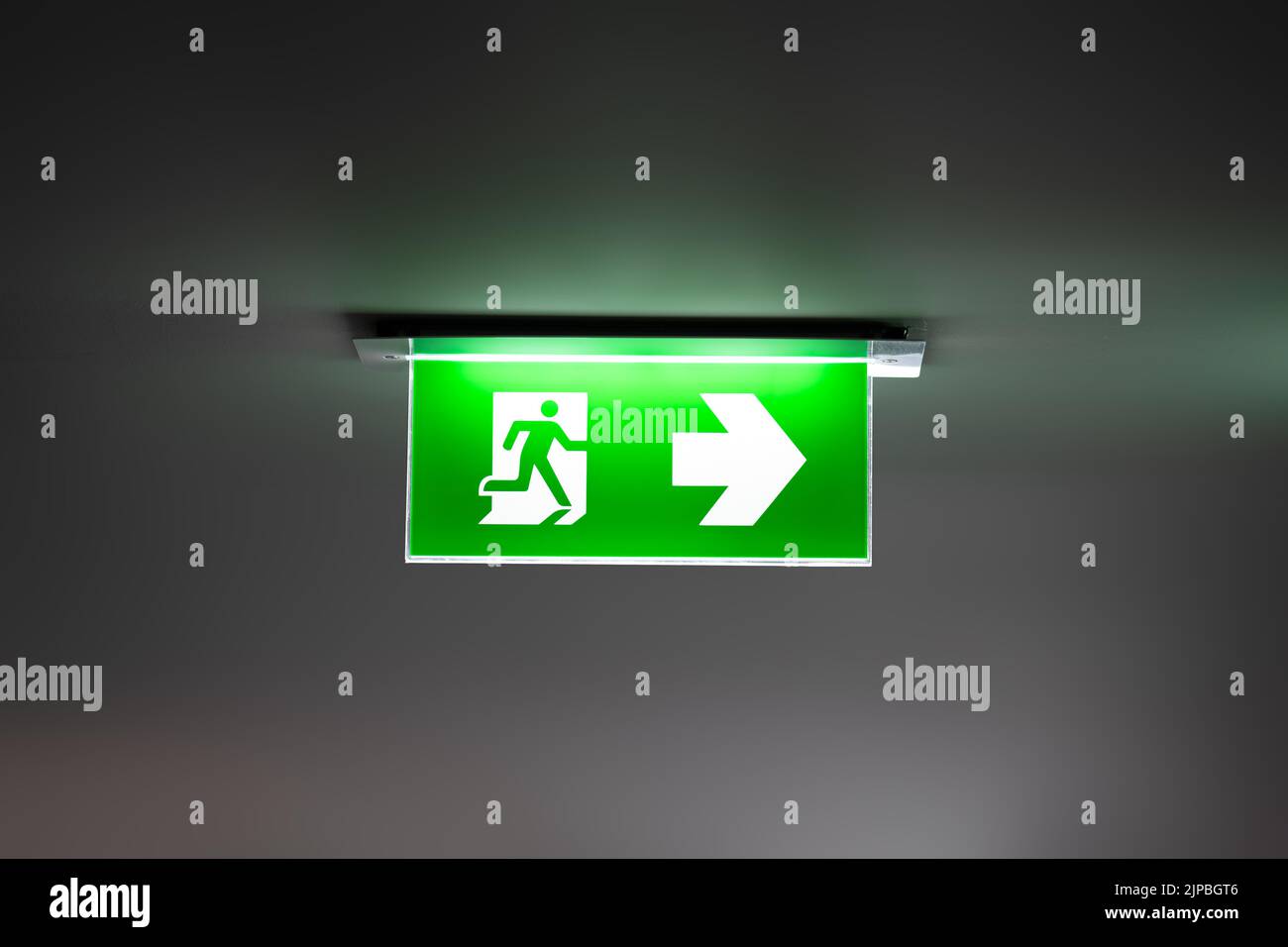 fire exit sign light box is hung on the ceiling in hotel walk way Stock ...