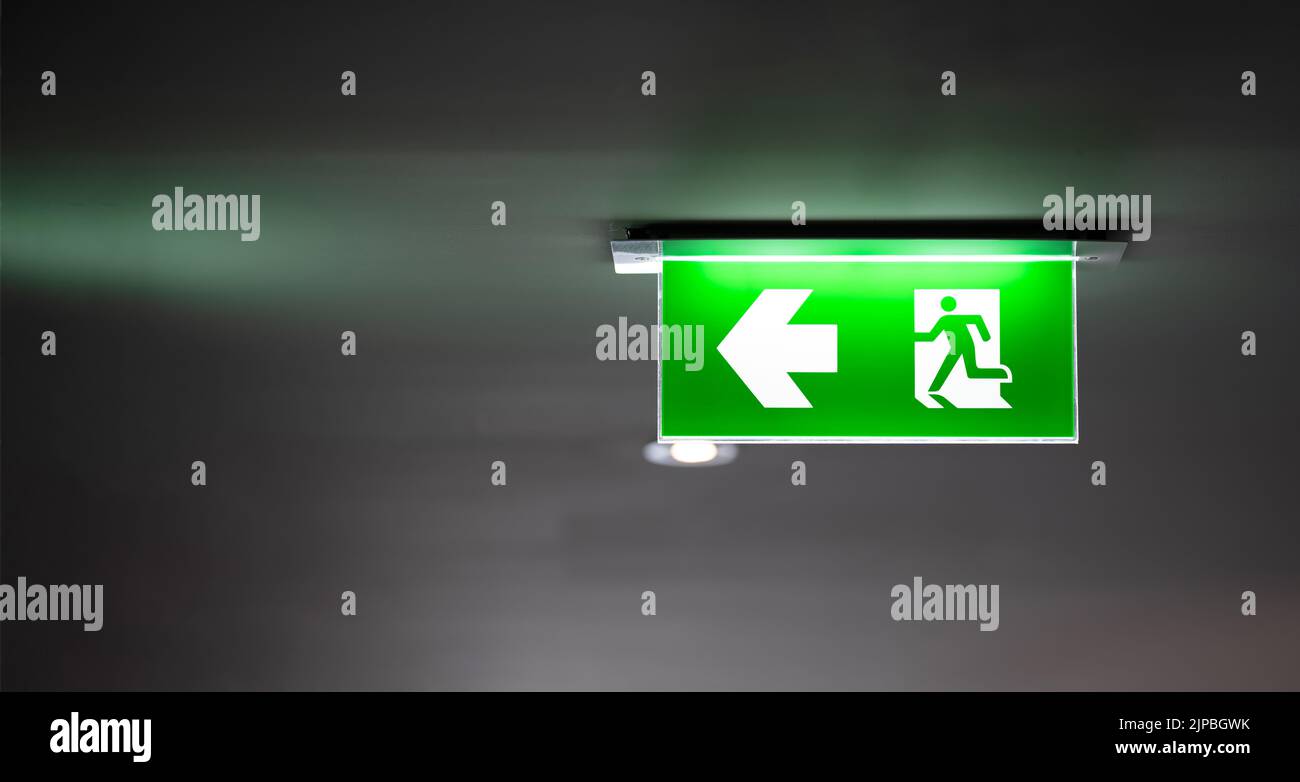 fire exit sign light box is hung on the ceiling in hotel walk way Stock ...