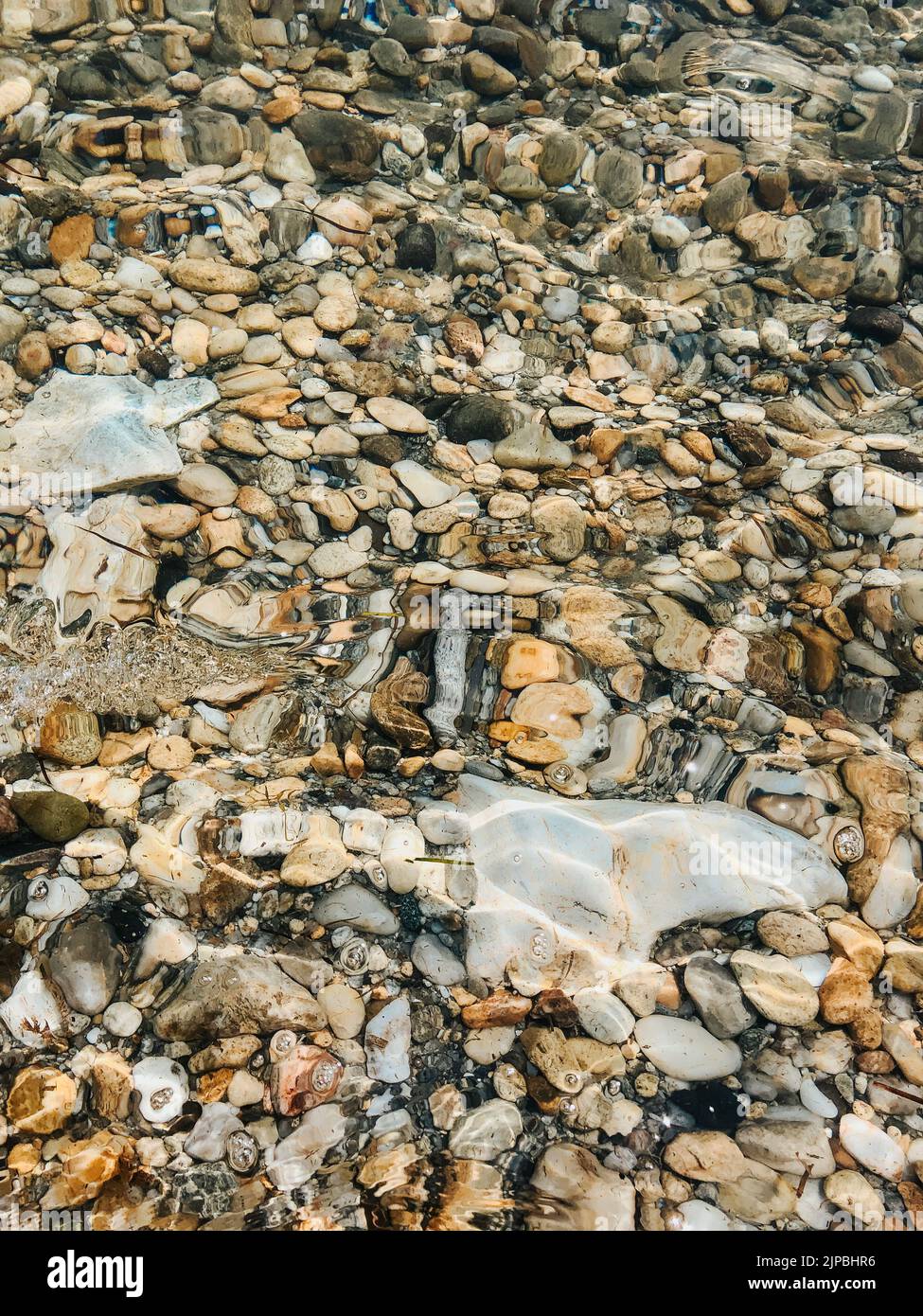 Close up sea waves stones shells beach summer day. top view above ...