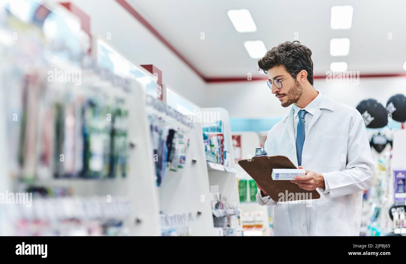 Checking on the inventory. a pharmacist working in a pharmacy Stock ...