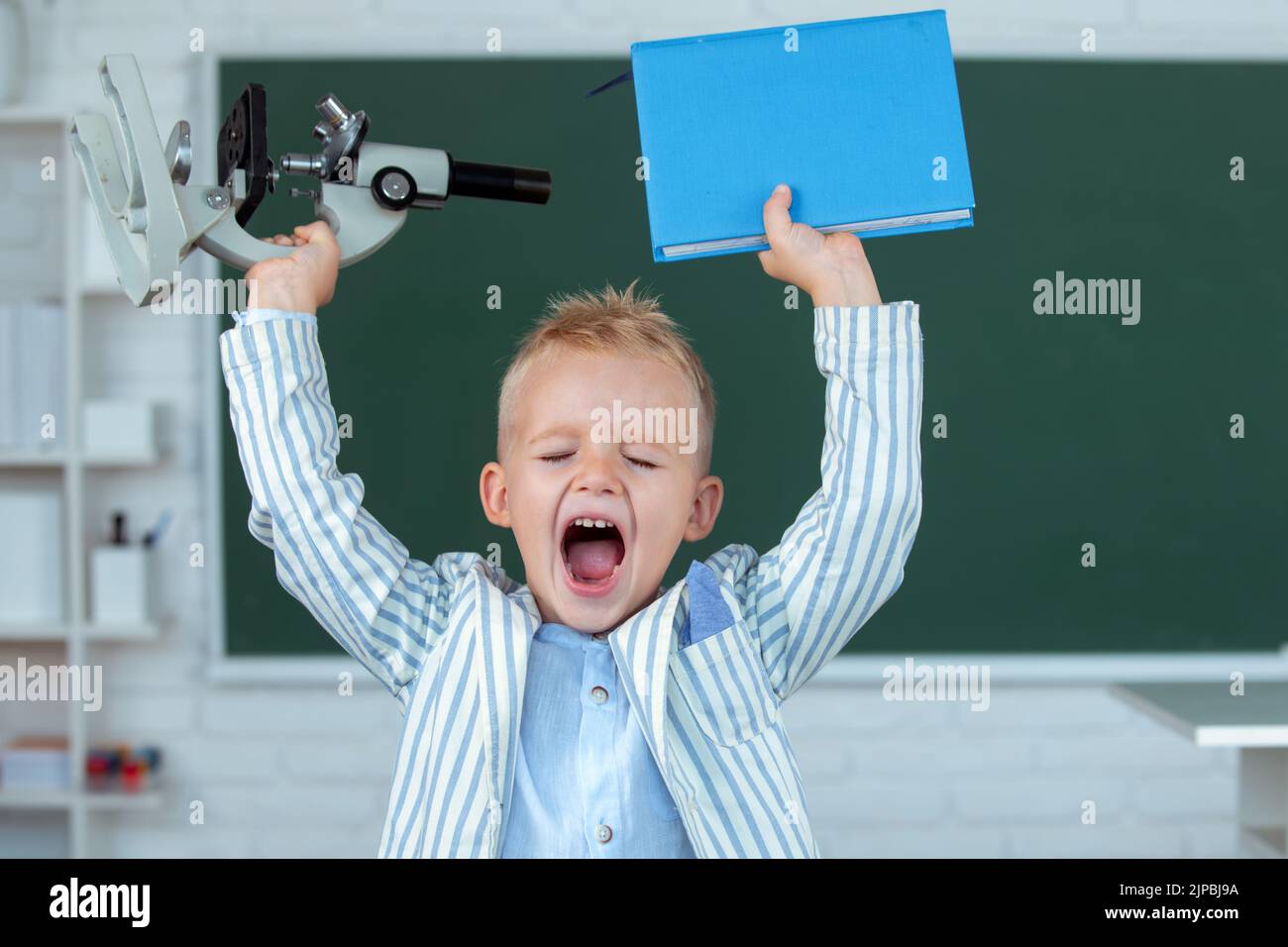 Portrait of funny pupil of primary school study in classroom at school ...