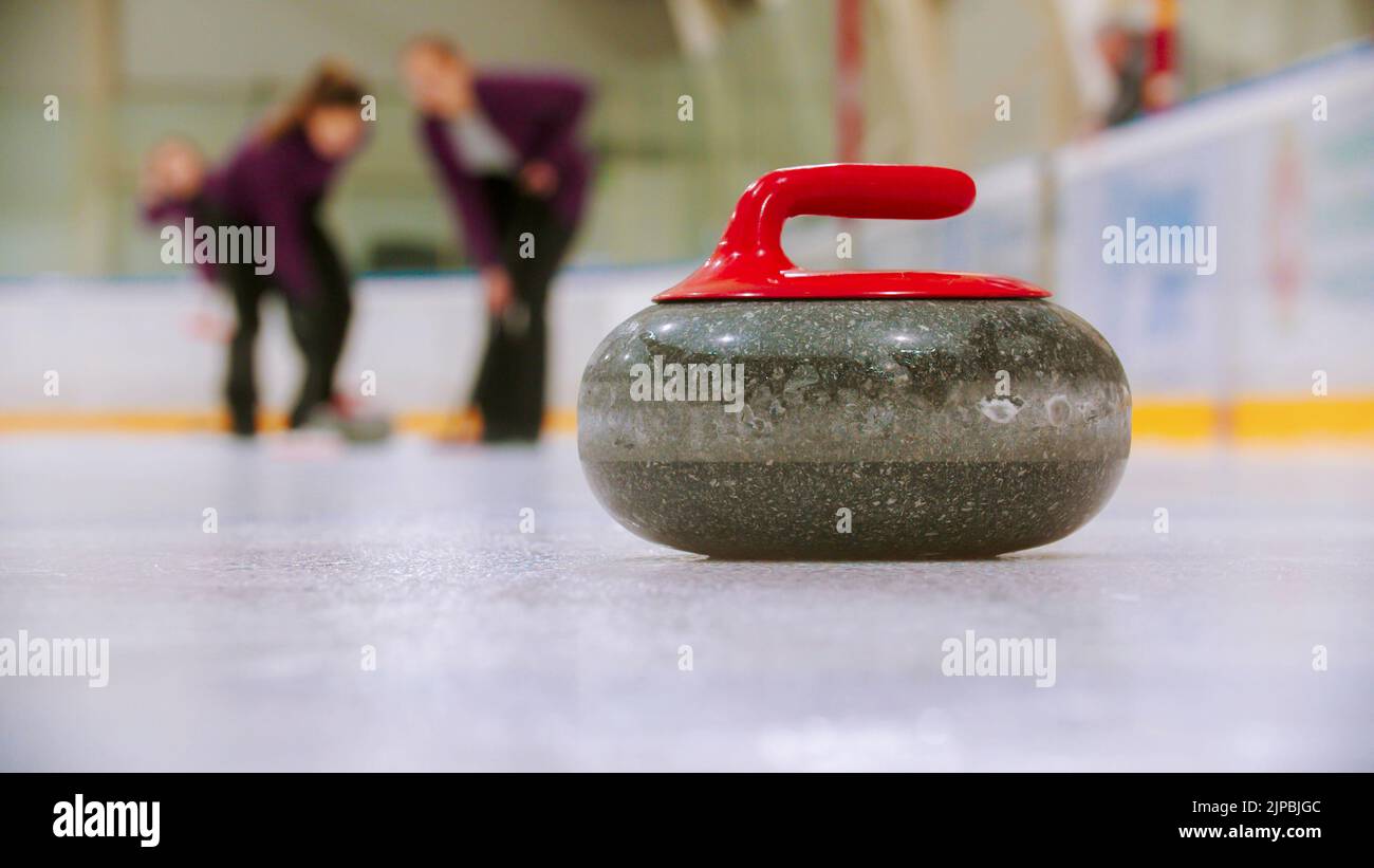 Curling - a granite stone with red handle on the ice field Stock Photo ...