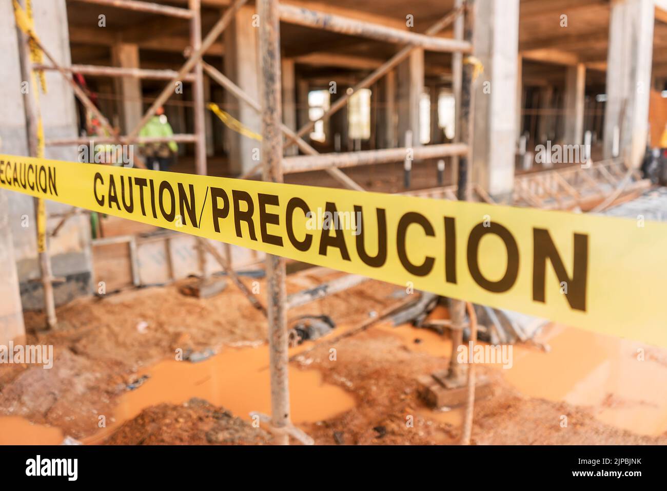 Caution tape with the word caution written in Spanish and English Stock ...