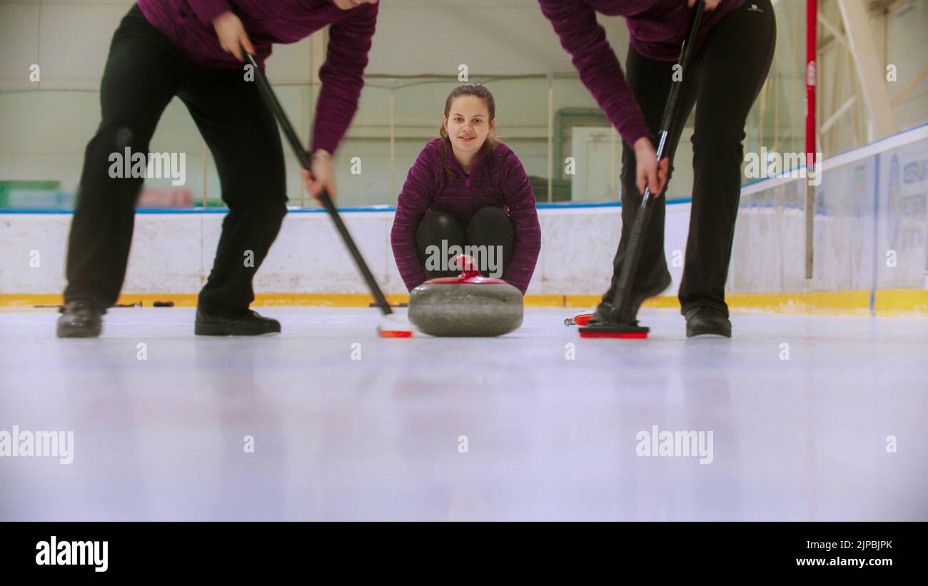 Curling - leading granite stone on the ice and rubbing the ice before ...
