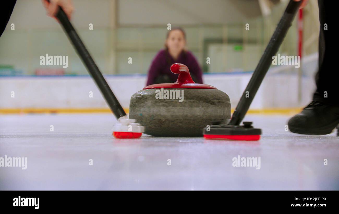 Curling training on the ice rink - leading granite stone on the ice and ...