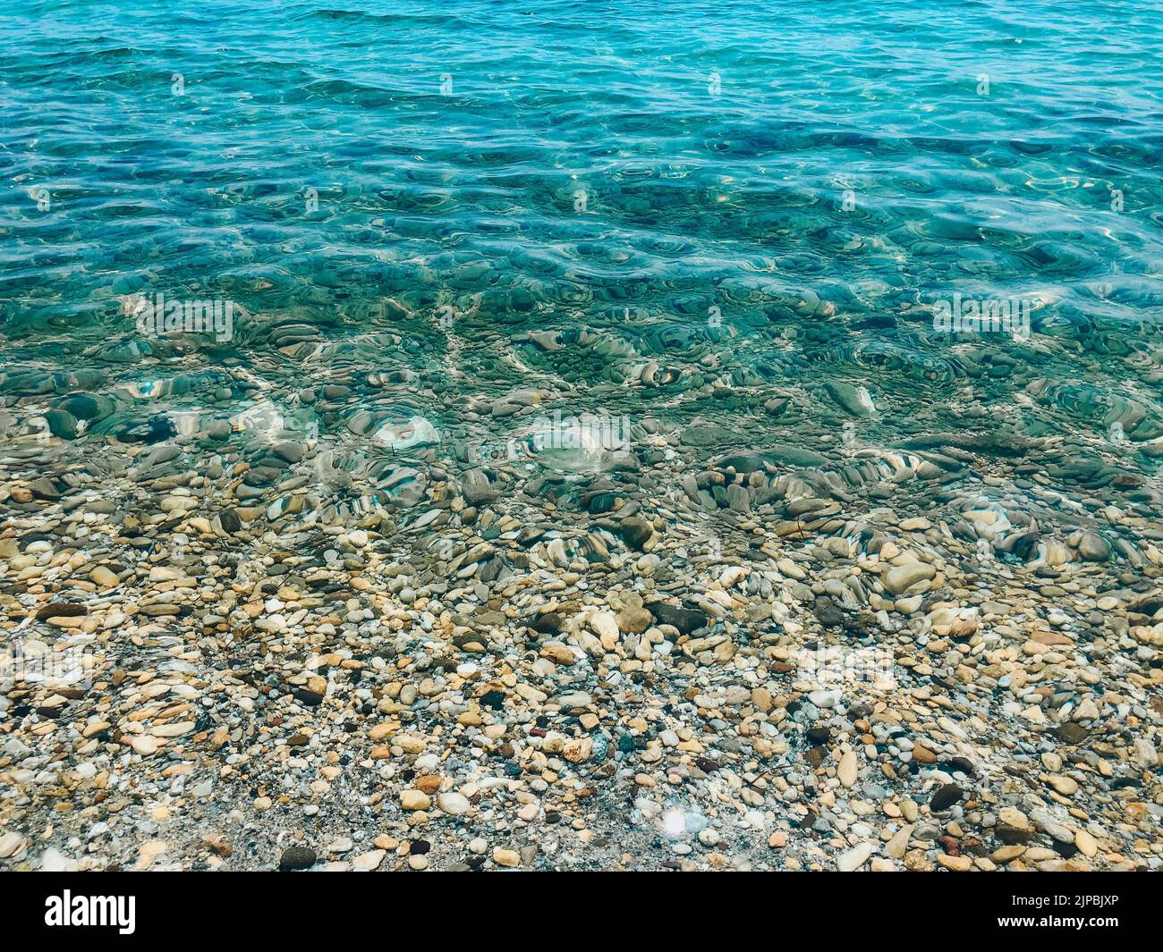 Close up sea waves stones shells beach summer day. top view above ...