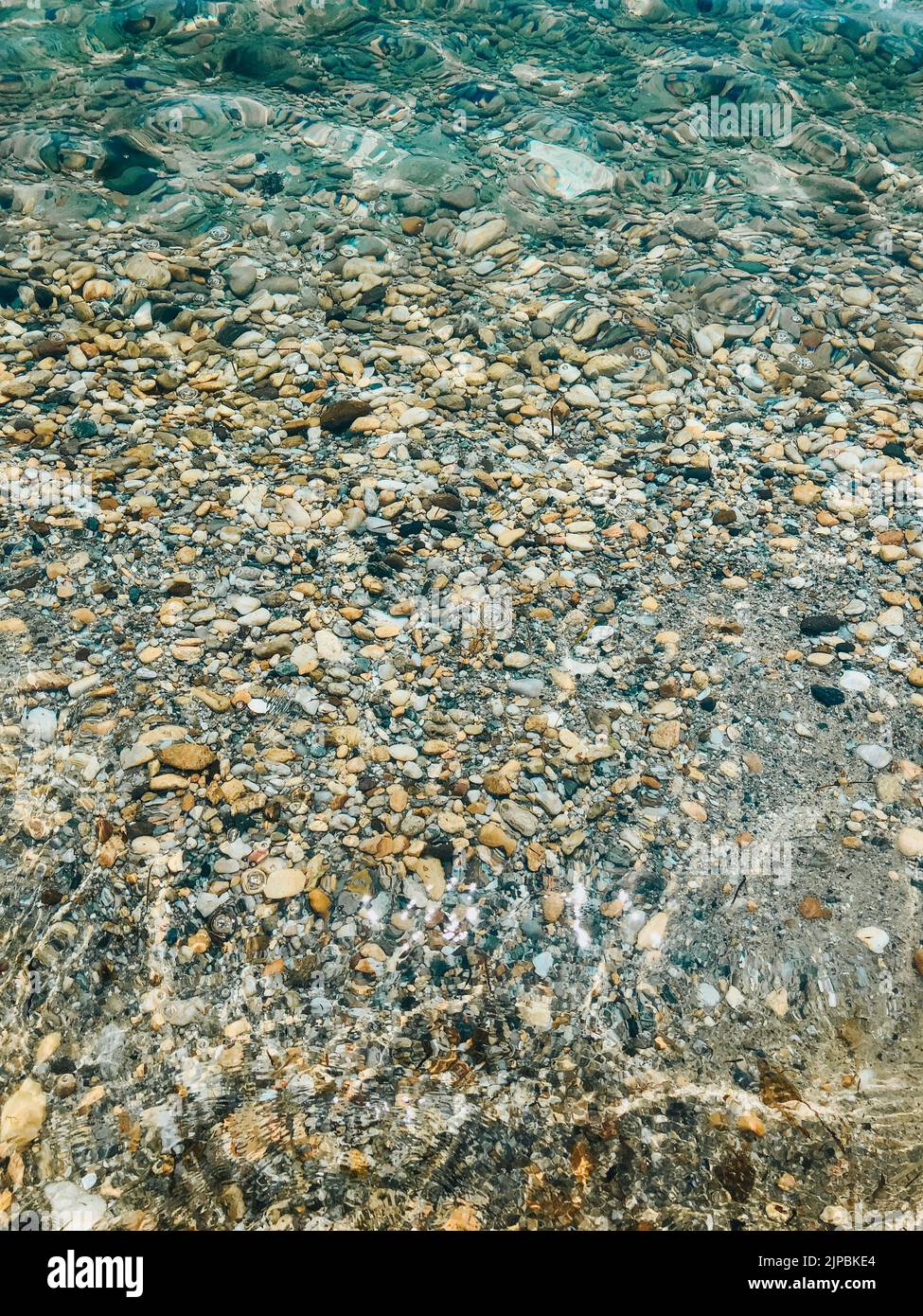 Close up sea waves stones shells beach summer day. top view above ...