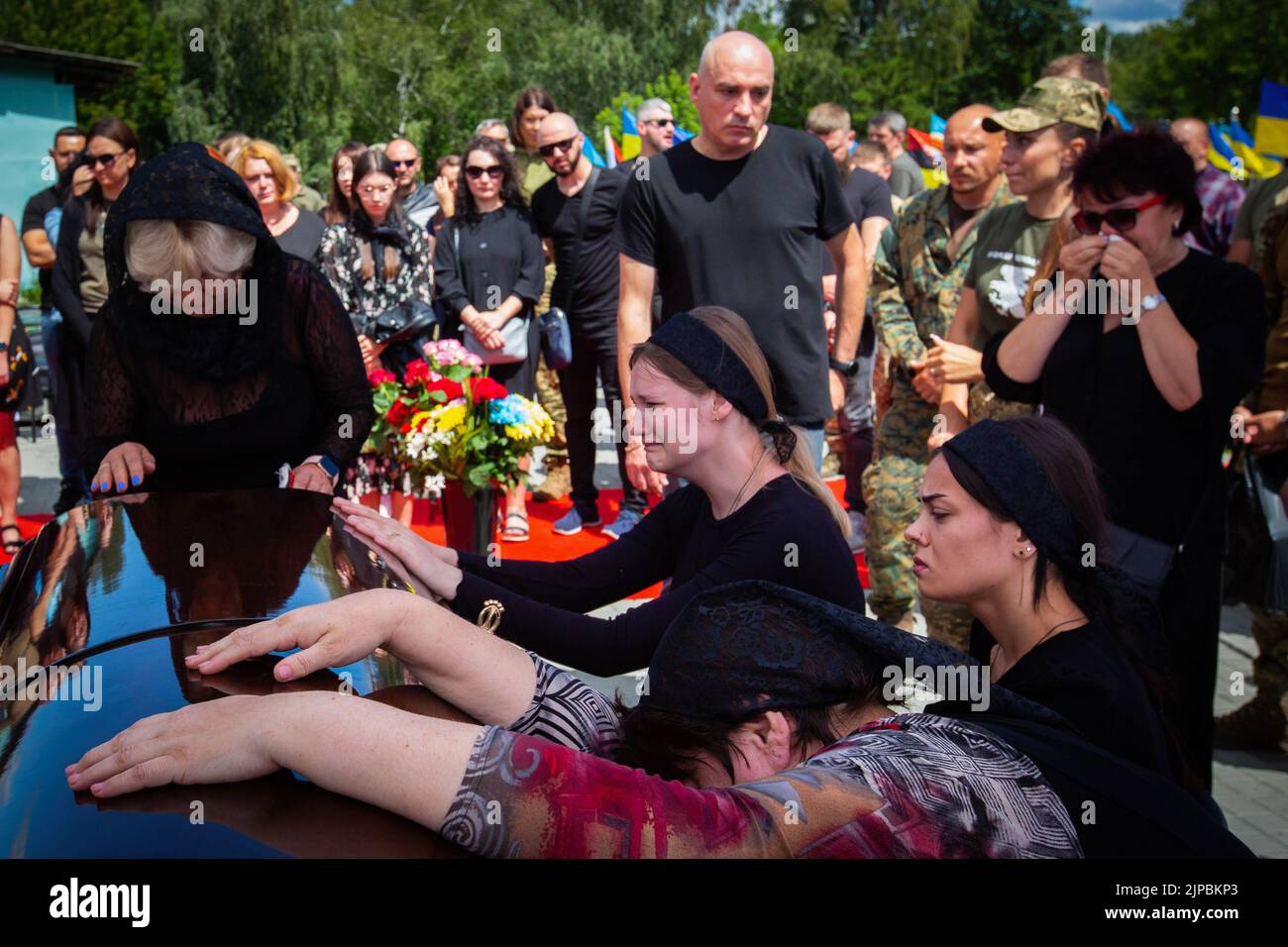 Relatives and friends mourn near the coffin during the funeral ceremony ...