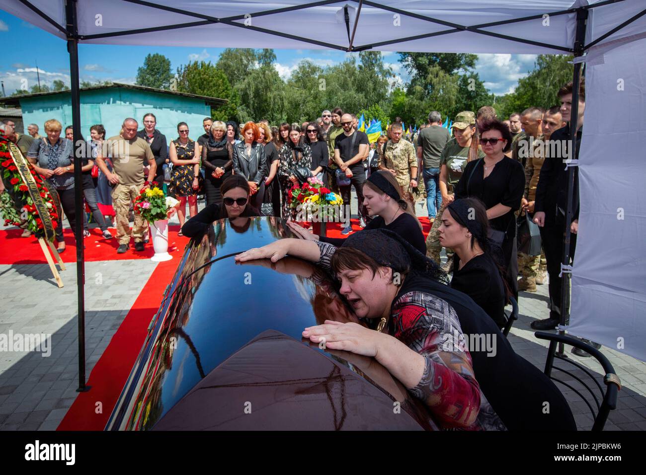 Relatives and friends mourn near the coffin during the funeral ceremony ...