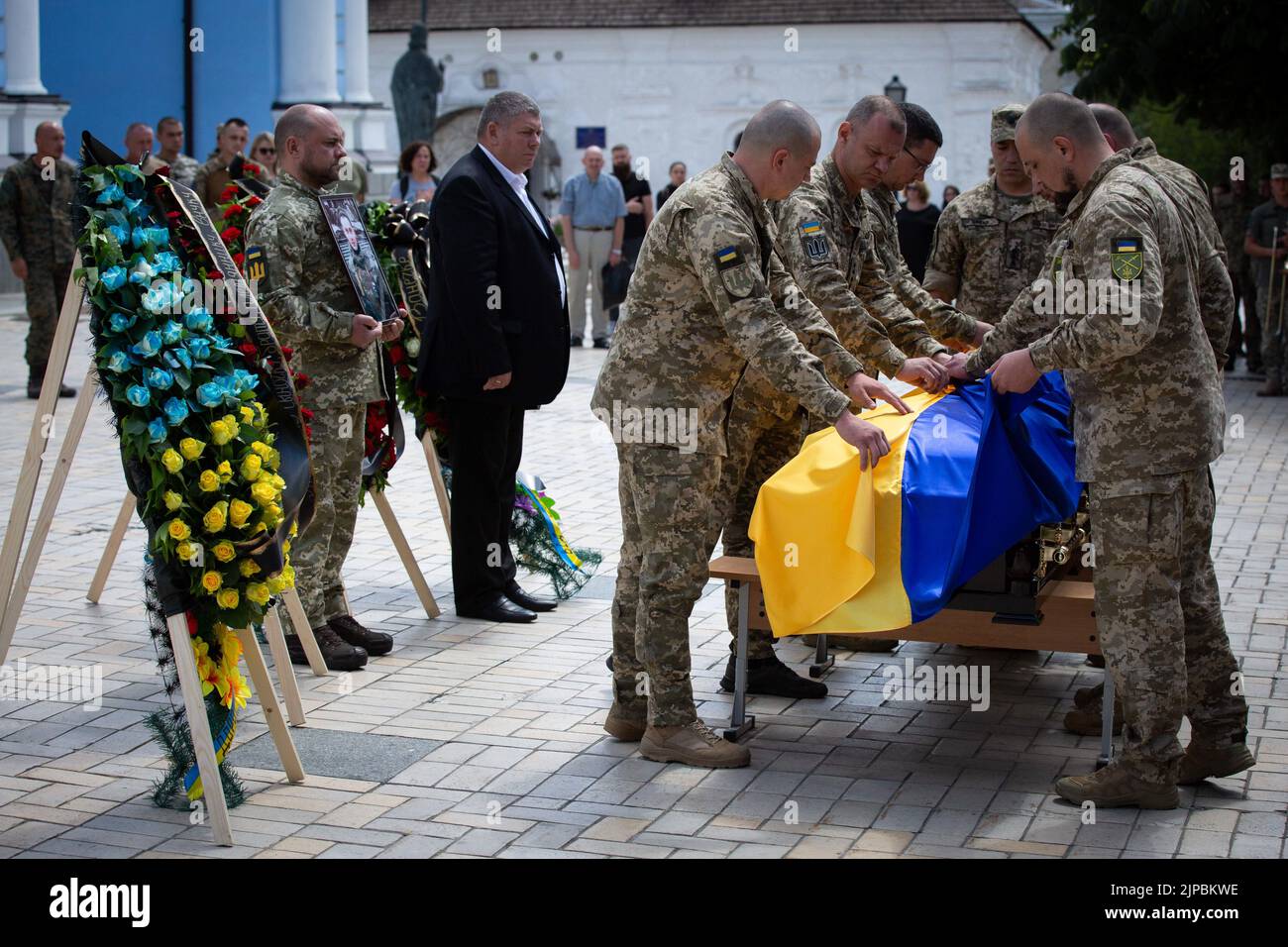 Soldiers cover the coffin with the national flag during the funeral ...