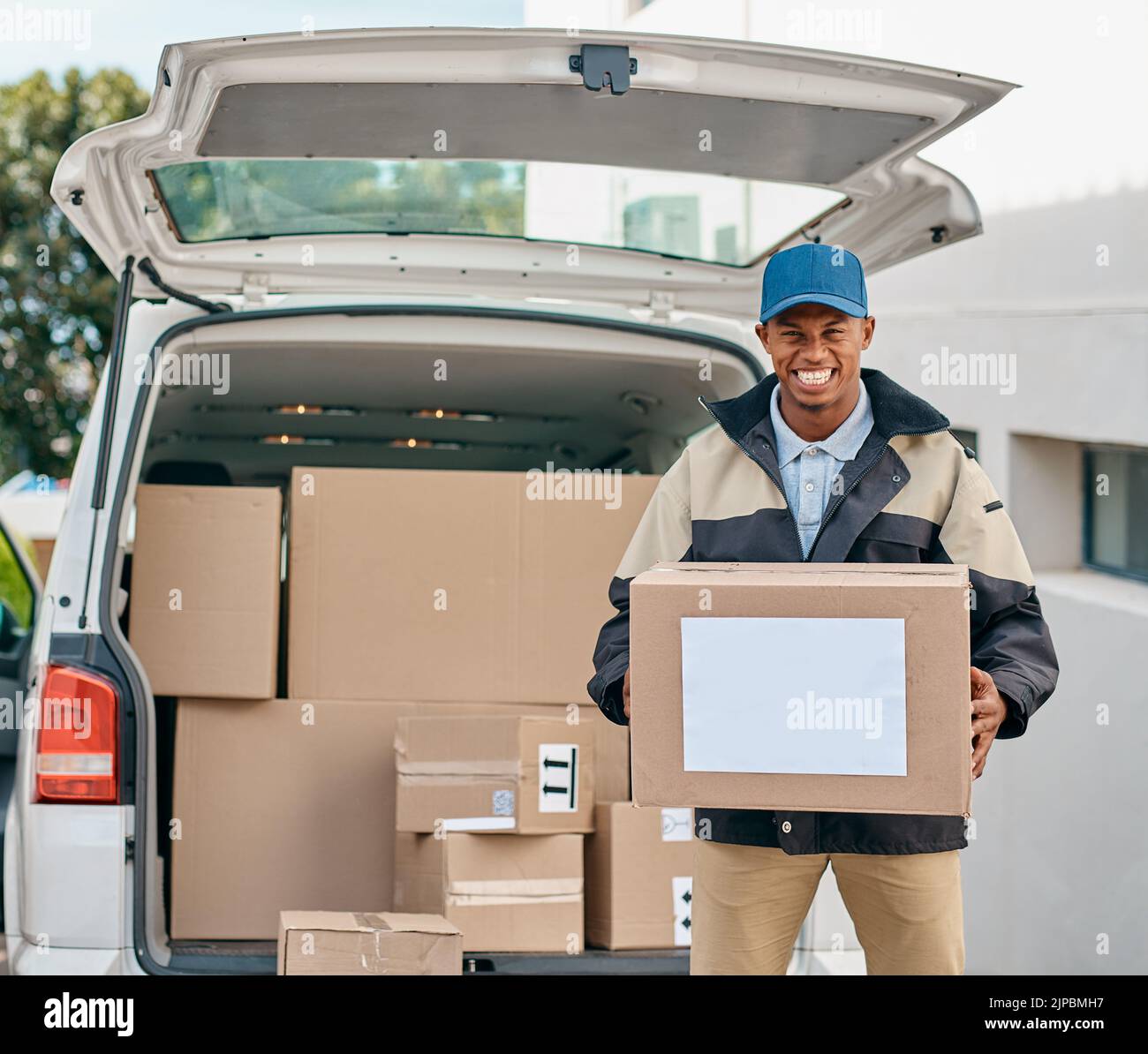 Doing his delivery rounds. Portrait of a courier unloading boxes from a ...