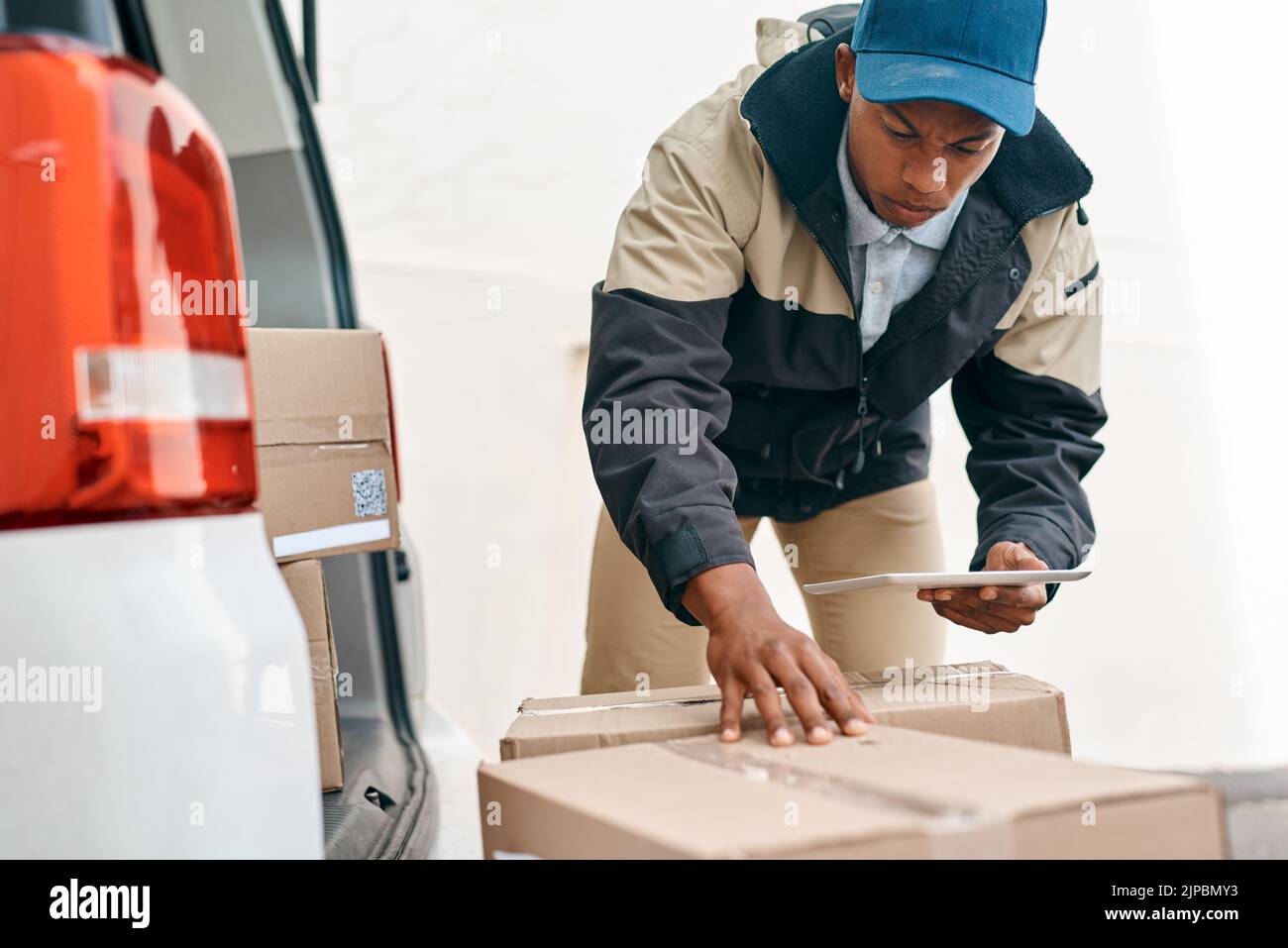 Double-checking his orders for delivery. a courier using a digital ...