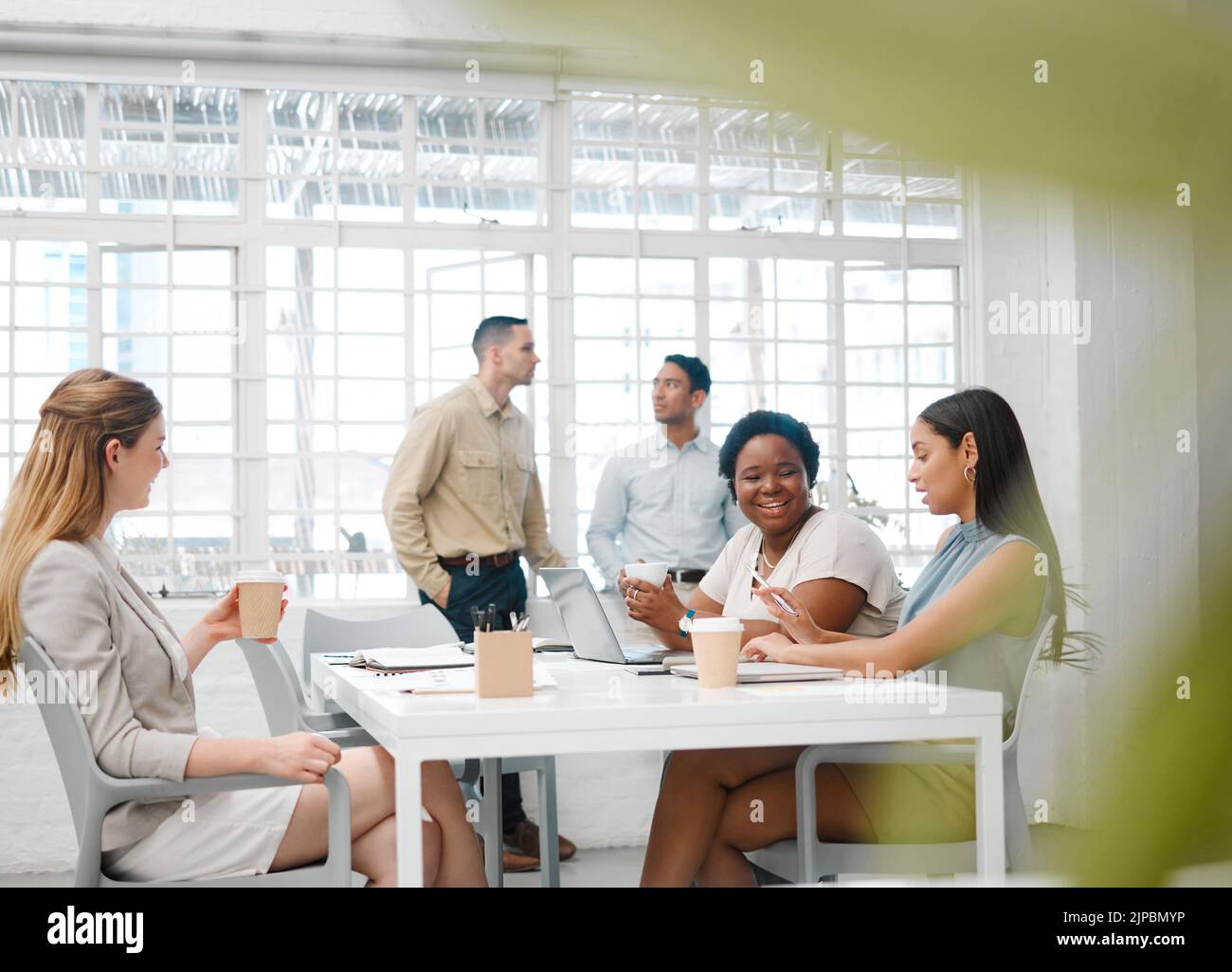 Happy, smiling and friendly colleagues talking on their coffee break or ...