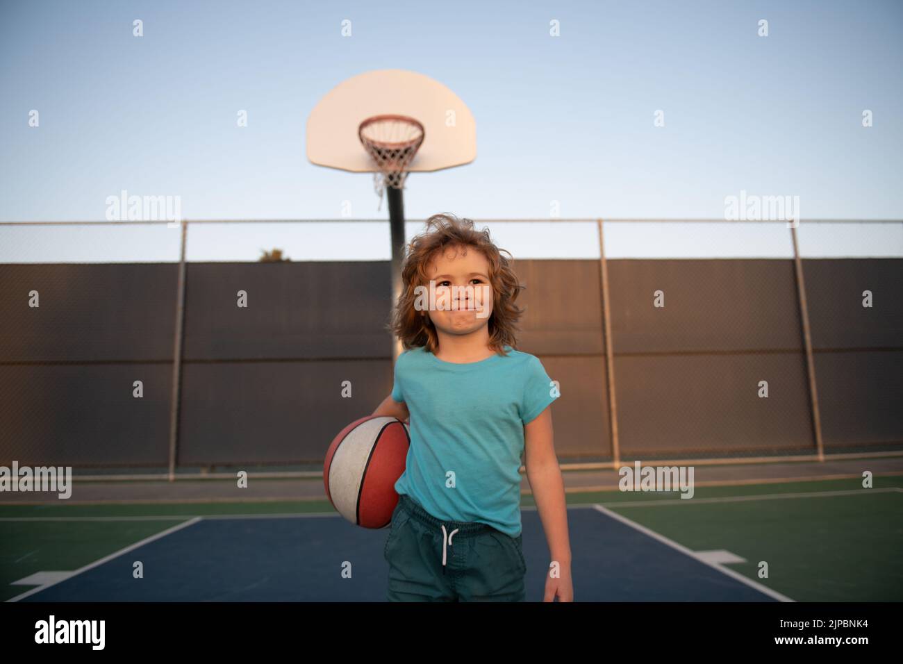 Little caucasian sports kid playing basketball holding ball with happy ...