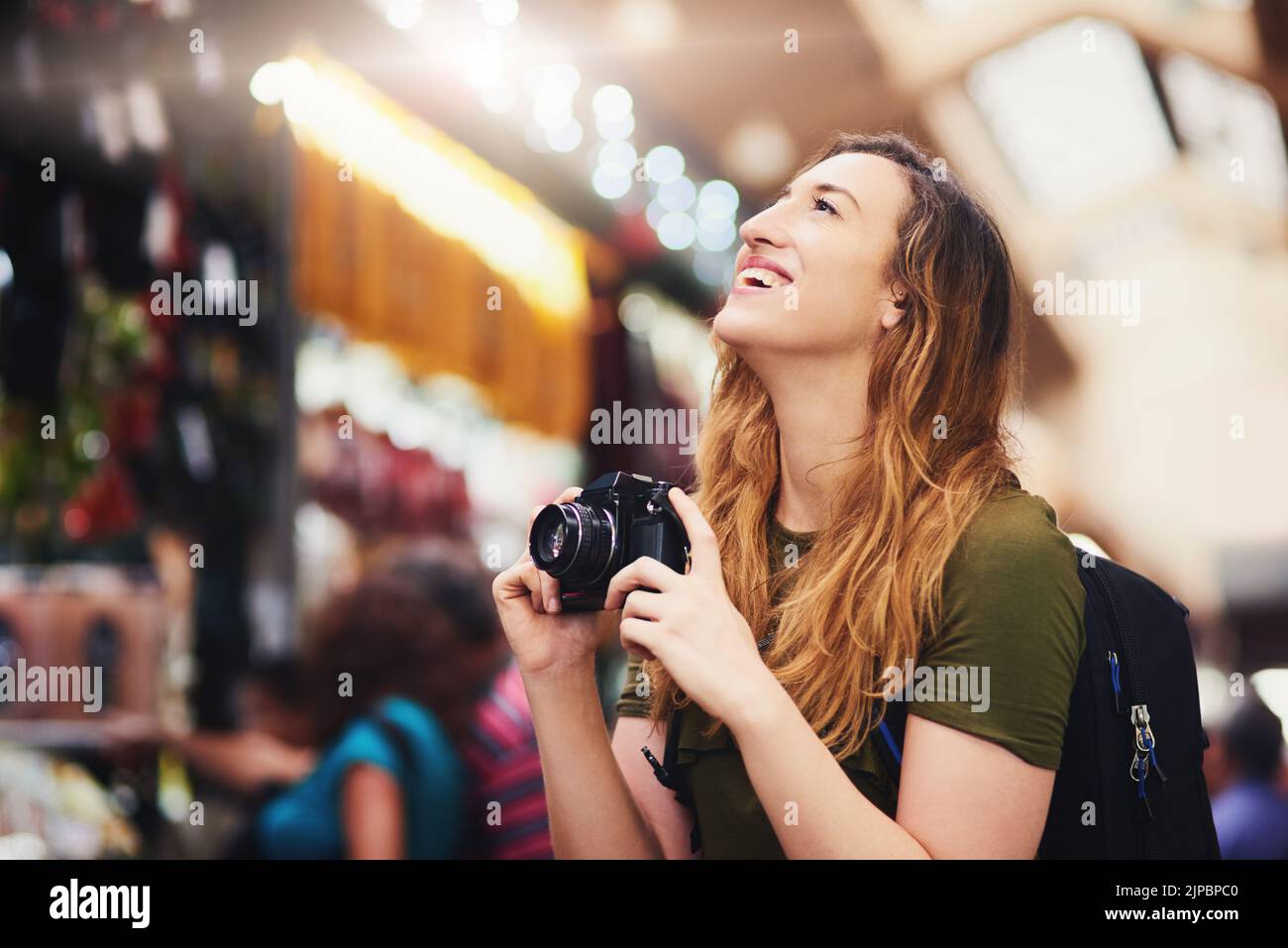 The world is a big place. a cheerful young woman taking photos of ...