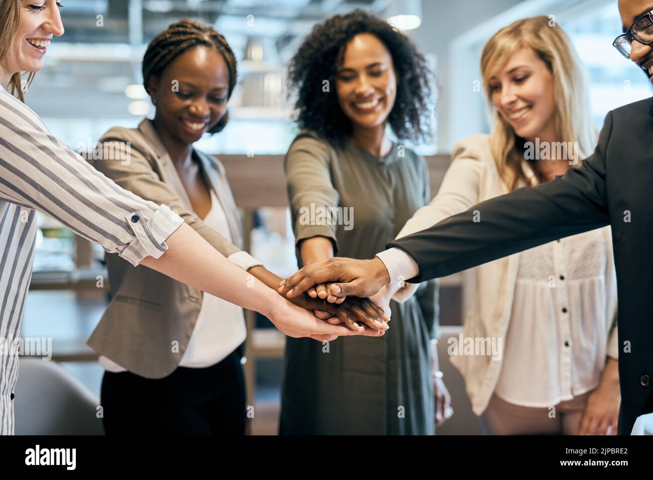 Lets bring it in for the team. two young businesspeople shaking hands ...