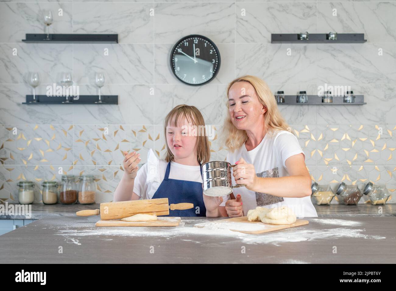 girl with down syndrome and her charming mother, bake dough pies in the ...