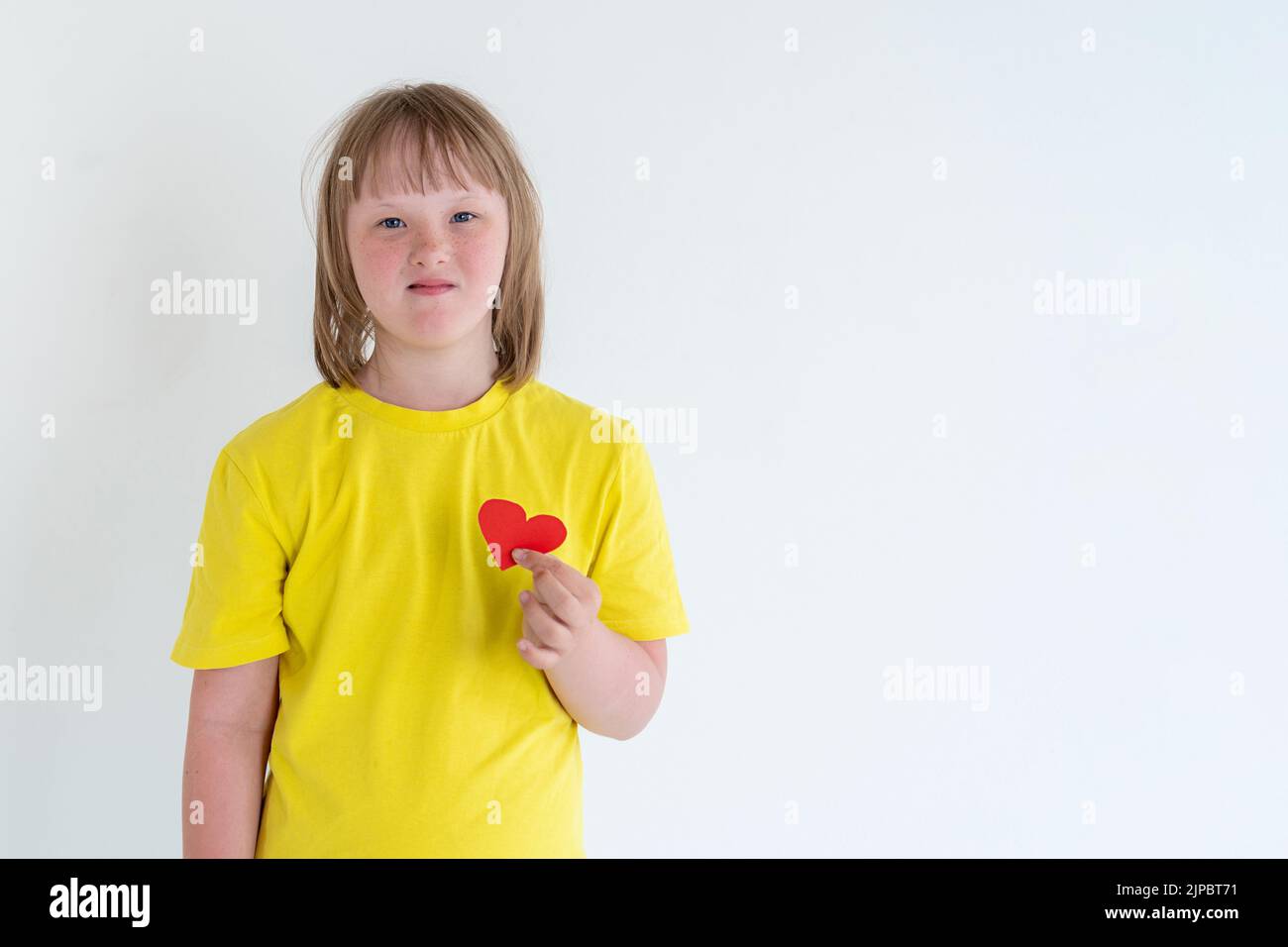 Sweet little girl with Down Syndrome, playing with paper heart. world ...
