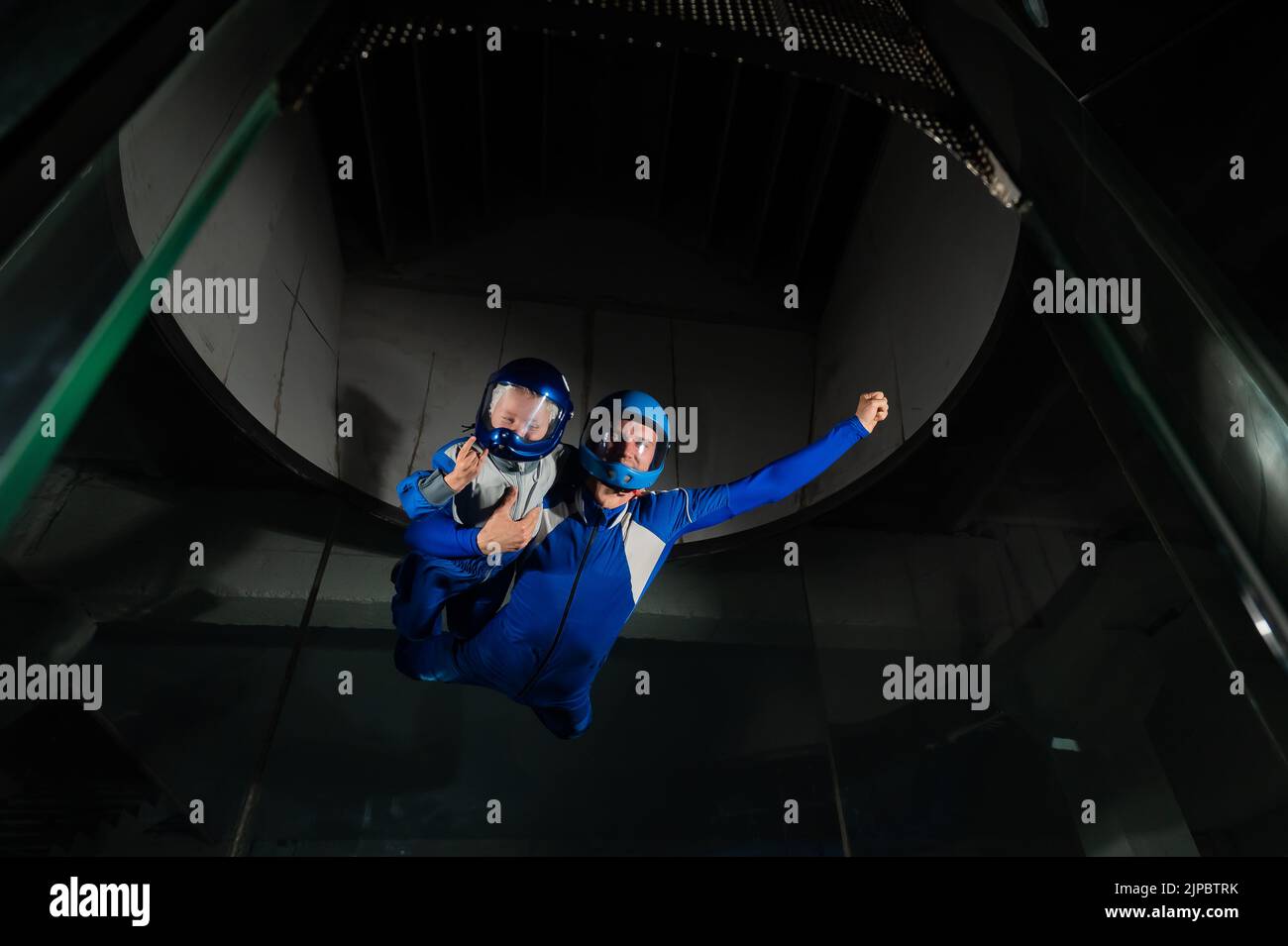 A man teaches a boy to fly in a wind tunnel. Lack of gravity Stock ...