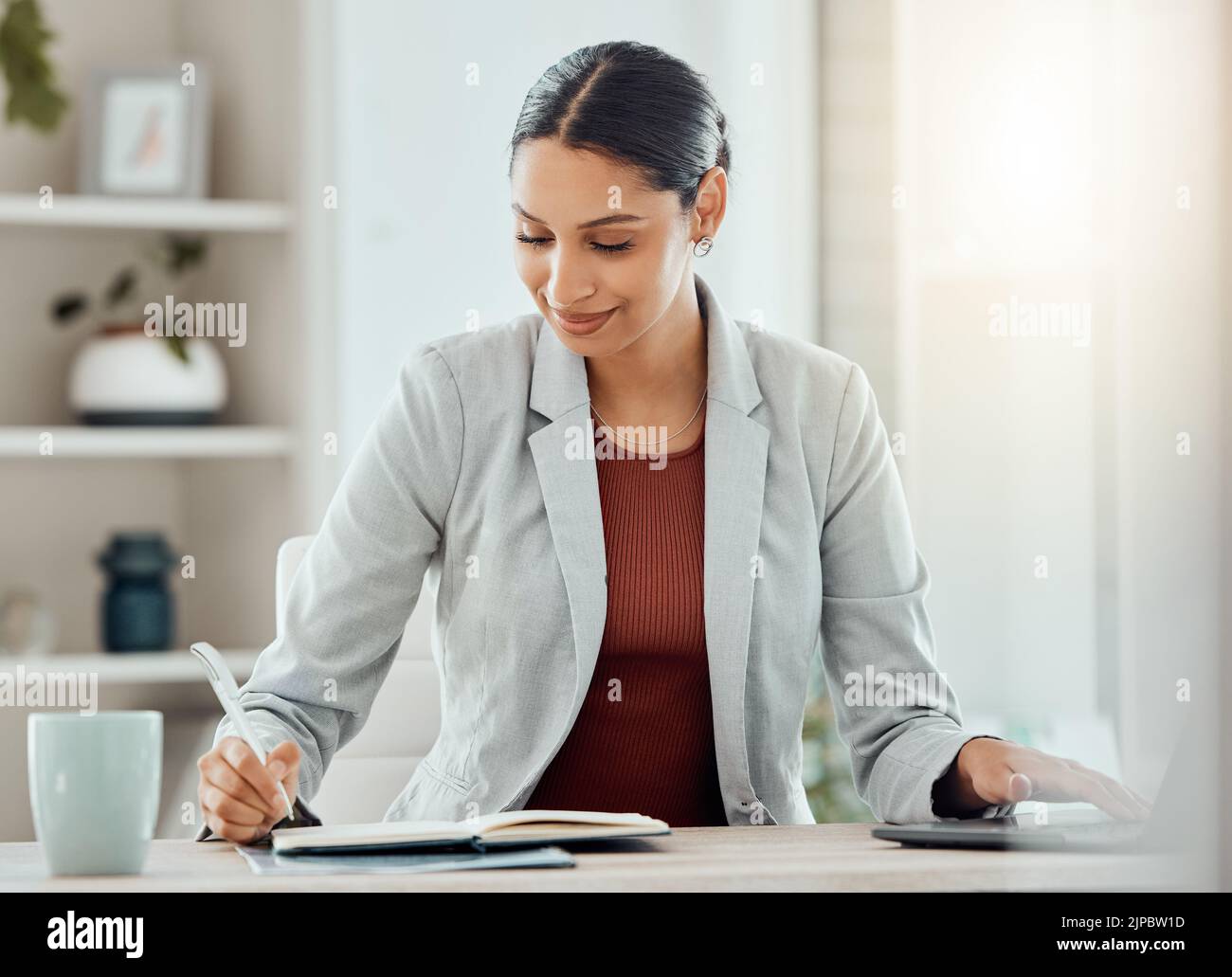 Female manager, boss or CEO writing notes in her diary, marking ...