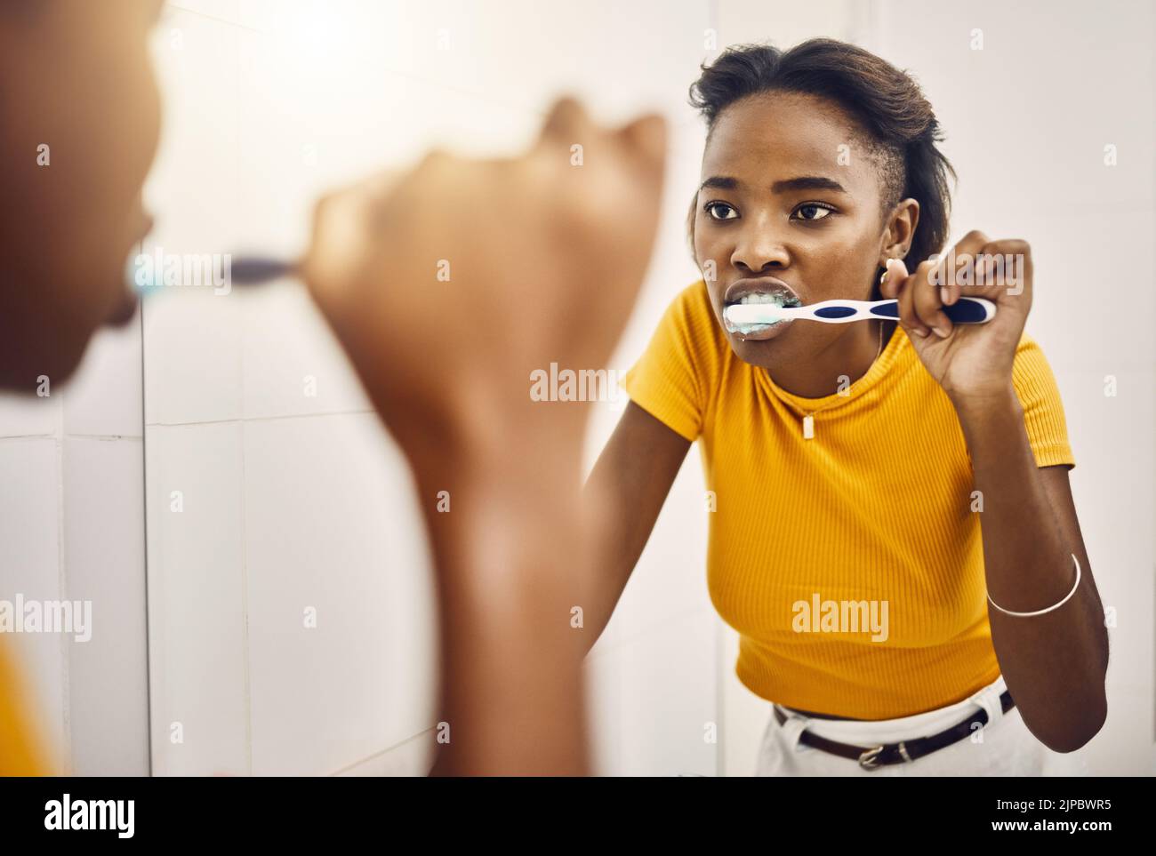 Brushing teeth, dental hygiene and oral care with a young woman looking ...