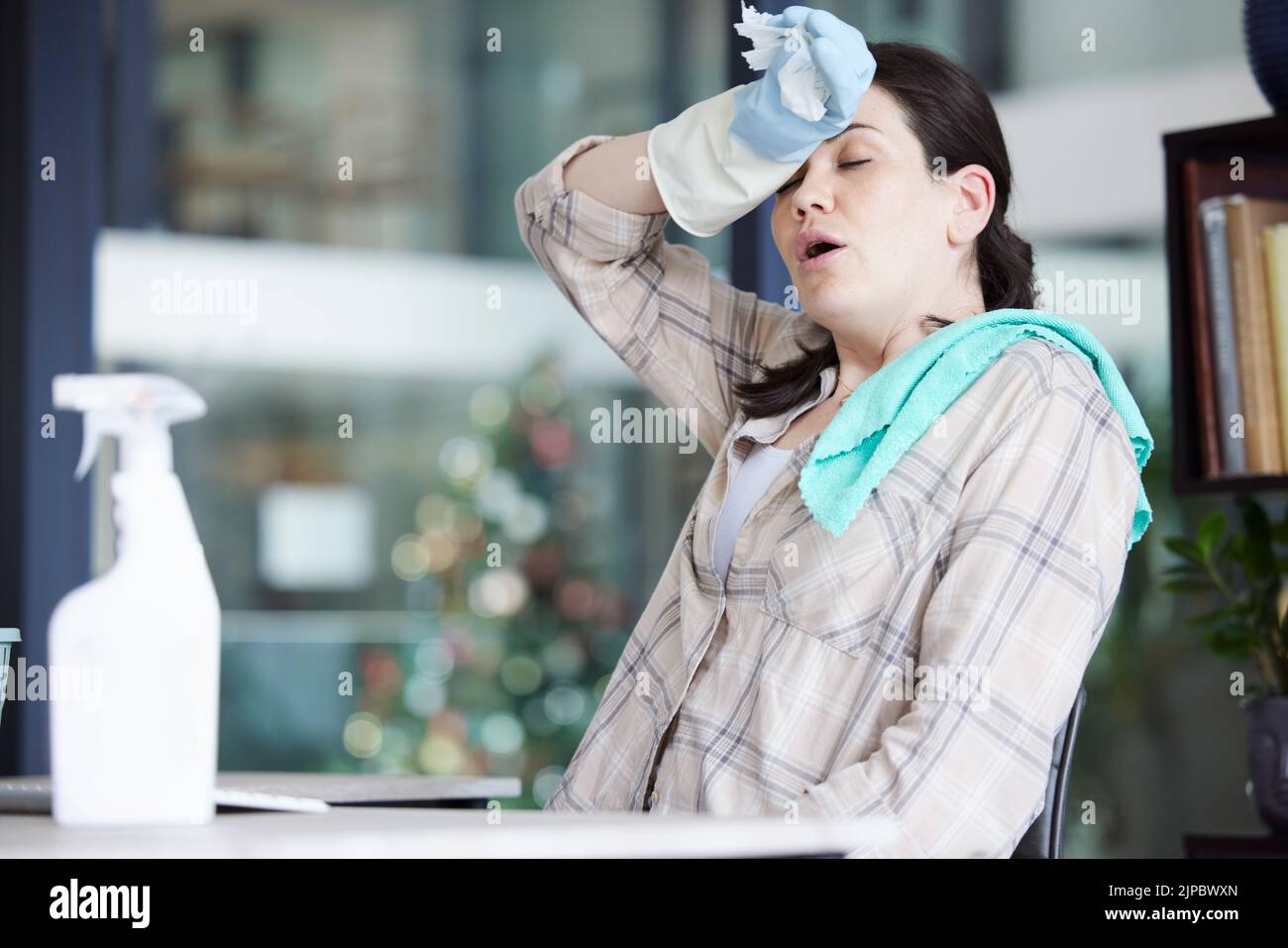 Tired, stressed and frustrated cleaning lady resting after doing chores ...
