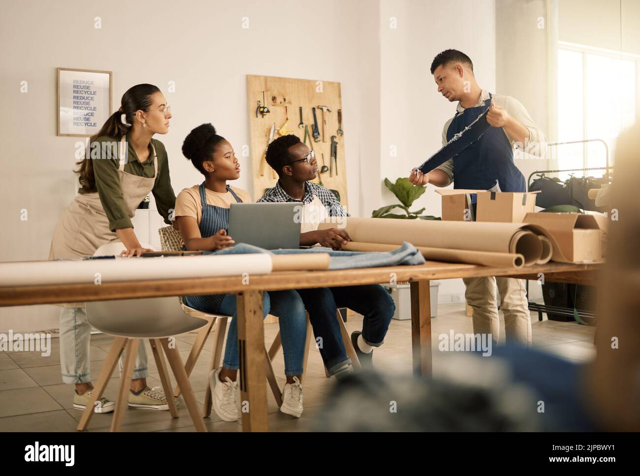 Serious, young and creative clothing designers planning with laptop ...