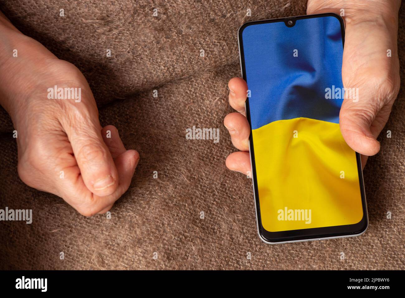 The national flag of Ukraine as a background on the phone in the hands ...
