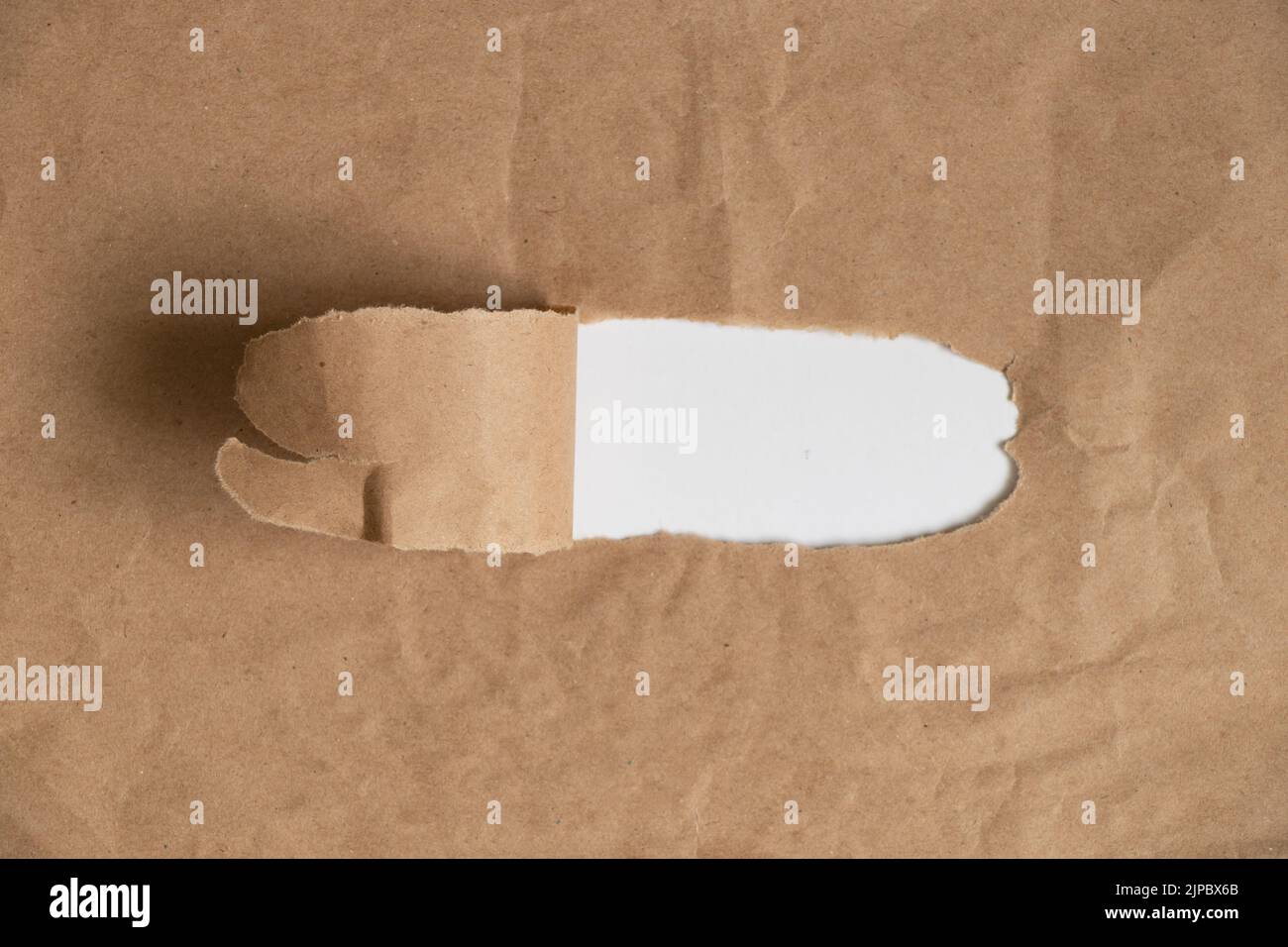 torn brown paper as background, space for text as wallpaper Stock Photo ...