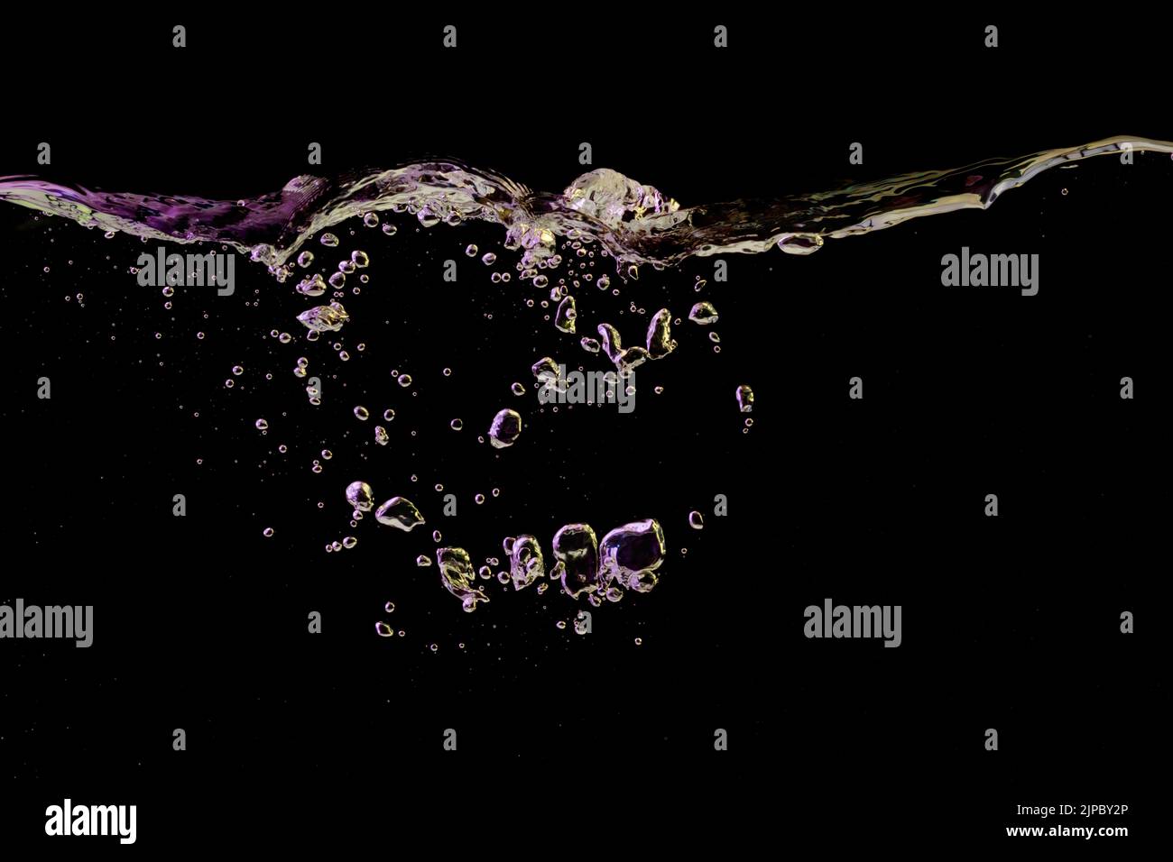 Clear water surface with ripple and bubbles in yellow and purple light ...