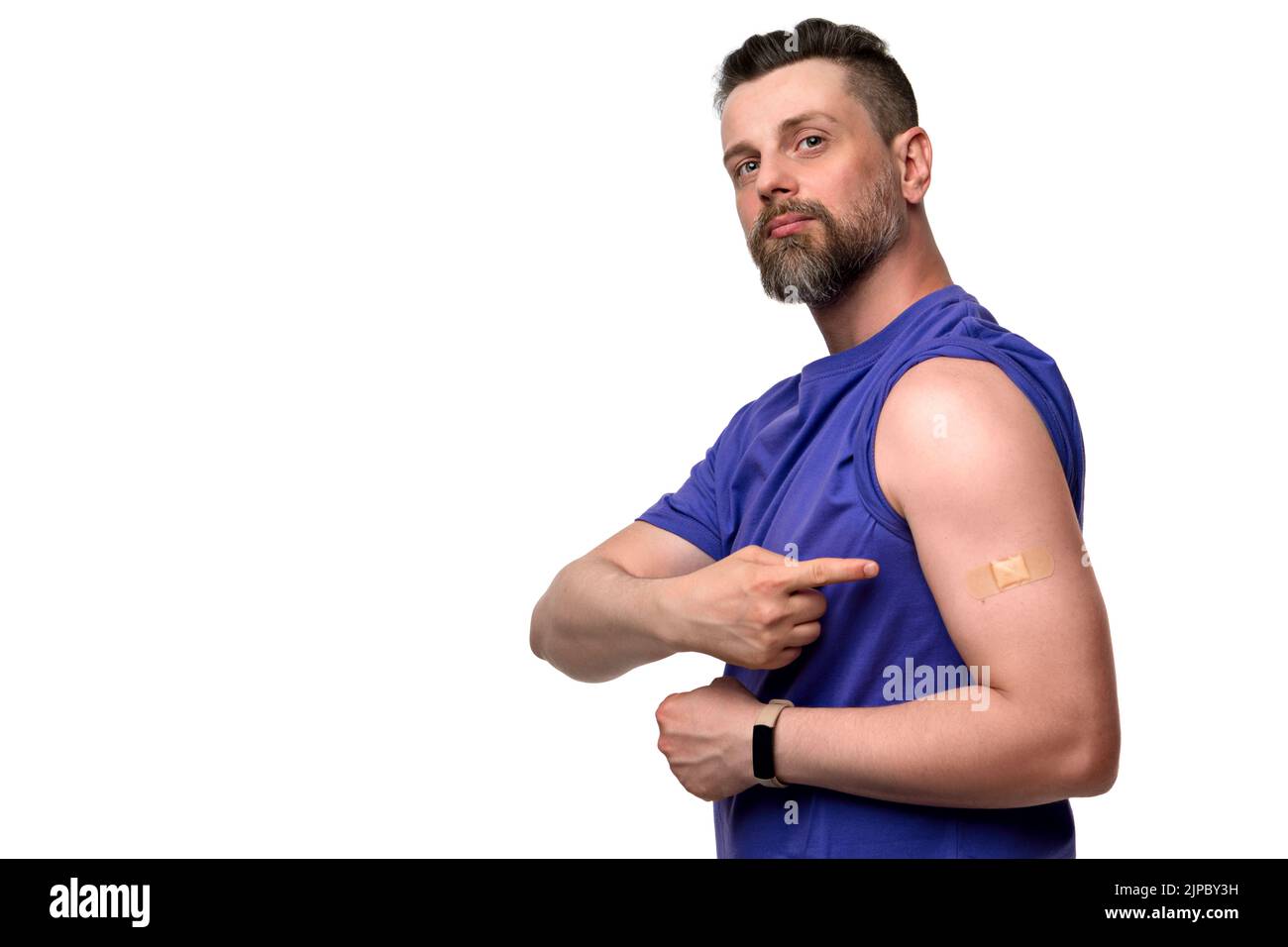 Handsome bearded man in violet t-shirt points finger at adhesive ...