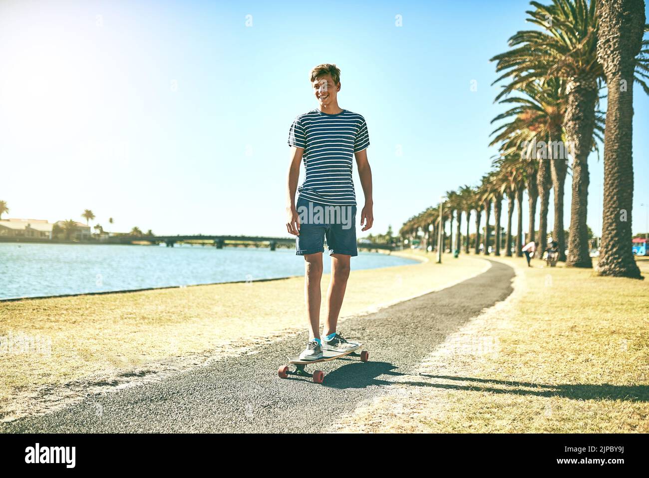 He loves being in the sun. Full length shot of a young boy skating on a ...