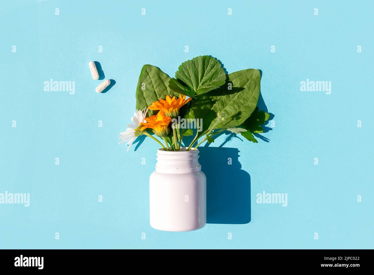 White pills and of bottle with herbal on blue background. Homeopathy ...