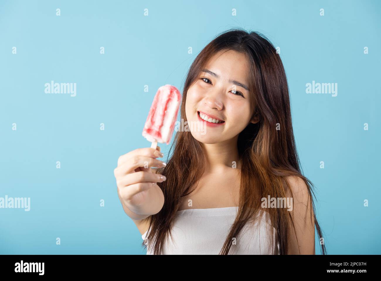 Portrait of happy Asian young beautiful woman holding delicious ice cream wood stick mixed fruit ...